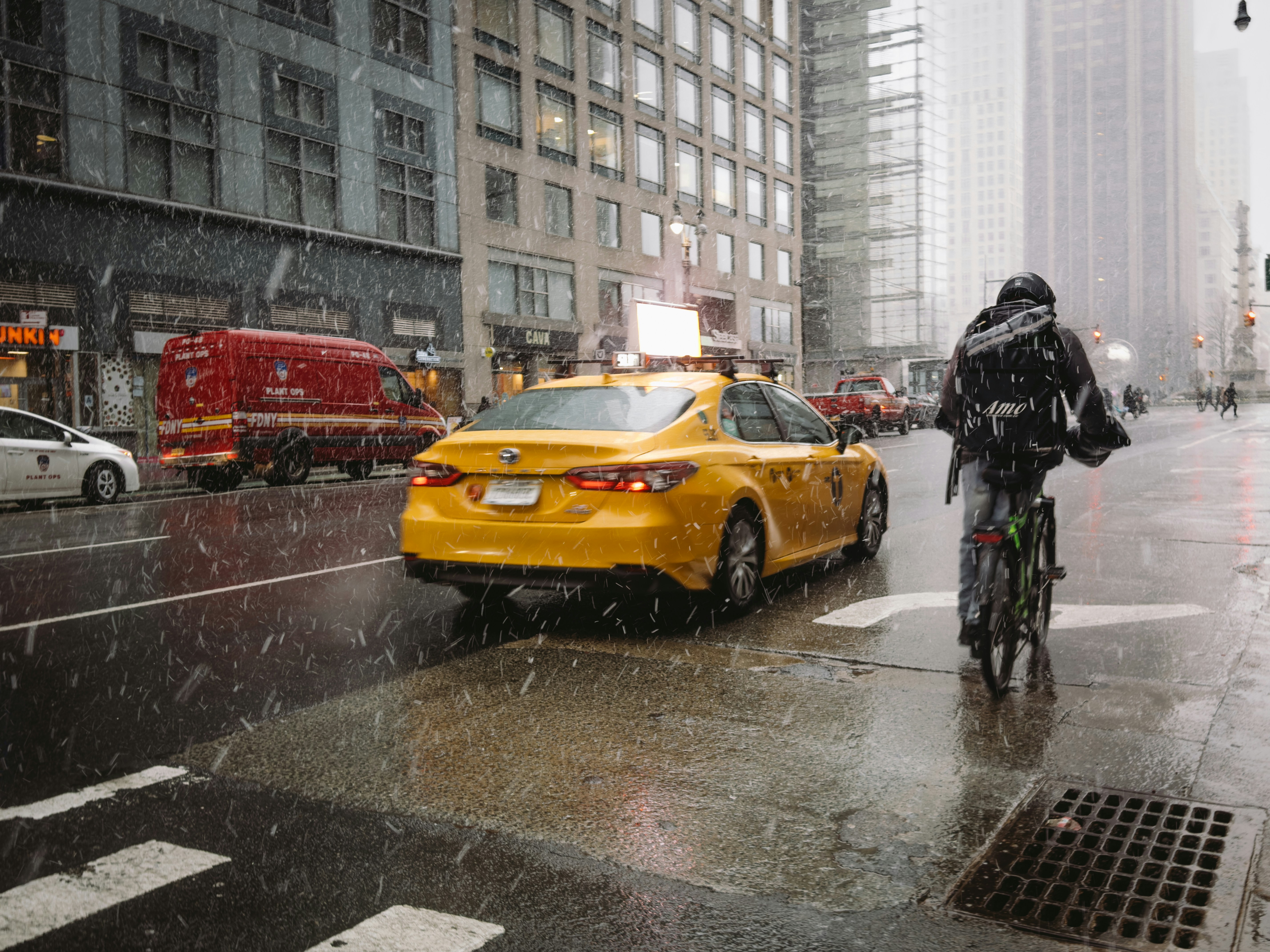 City Rain: Yellow Cab and Cyclist in a Wet Manhattan Street
