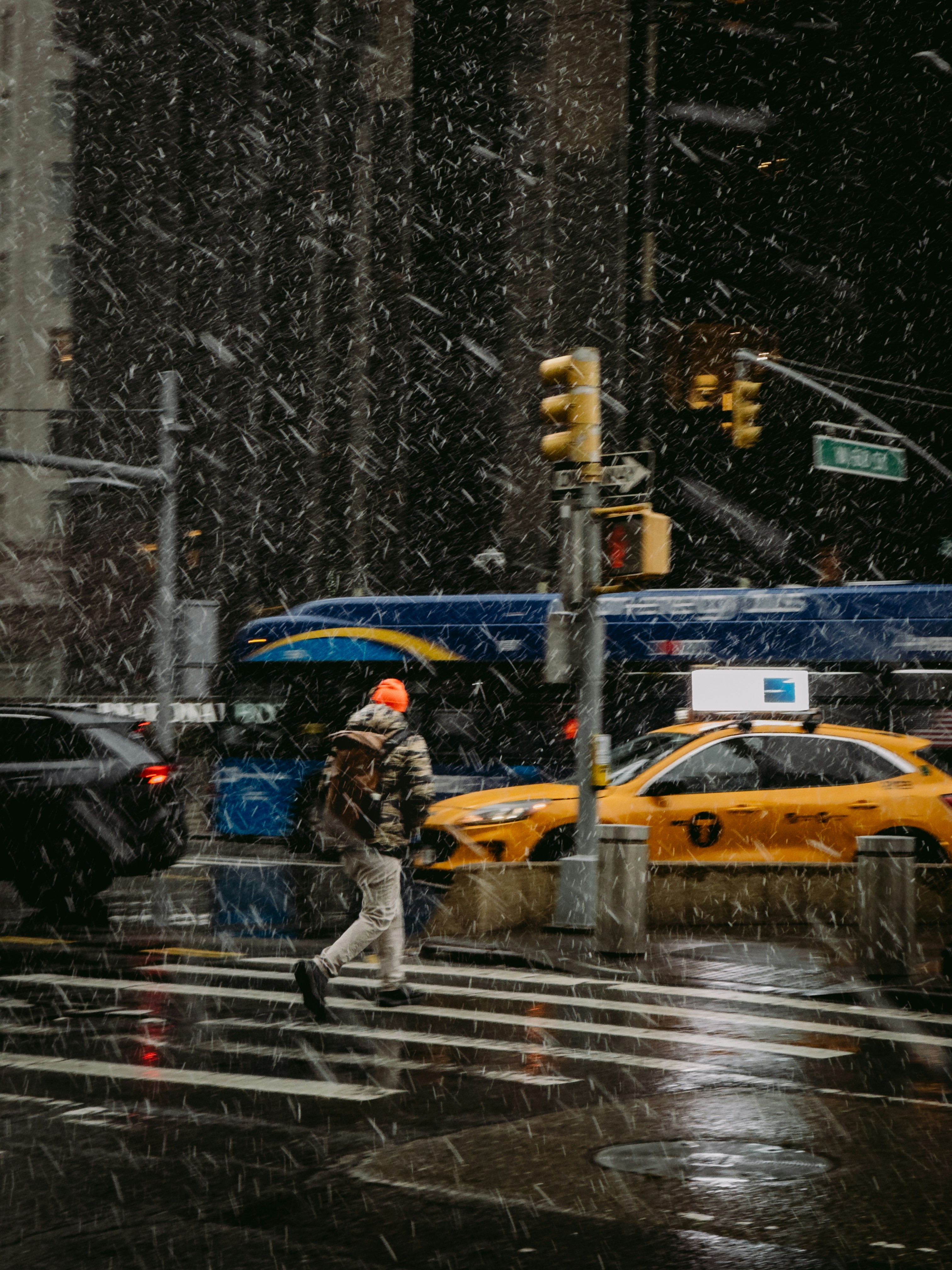 Crosswalk in Snow: A Lone Pedestrian Amid City Storm