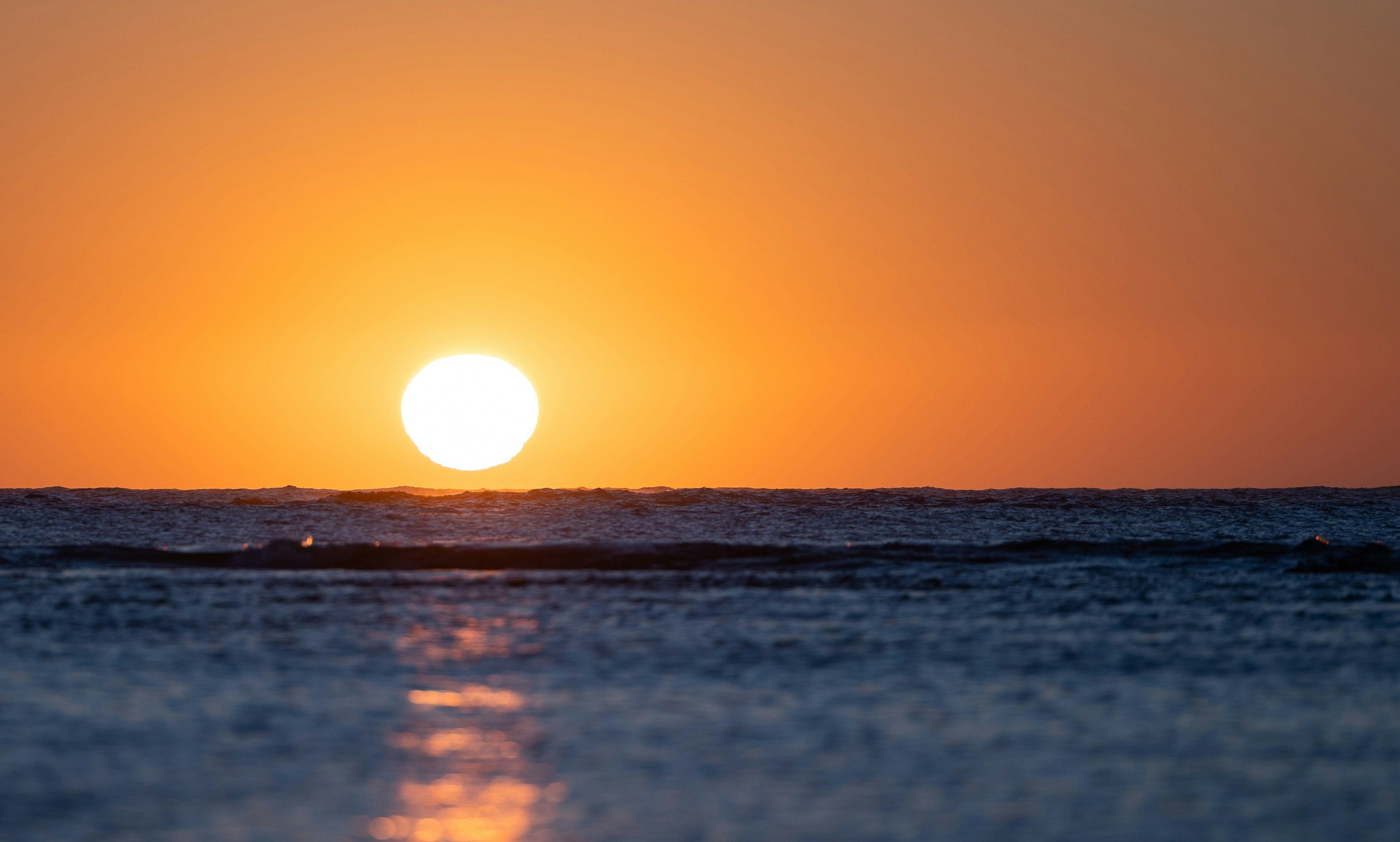 Orange Mirror: Sun Dips Over a Calmed Sea