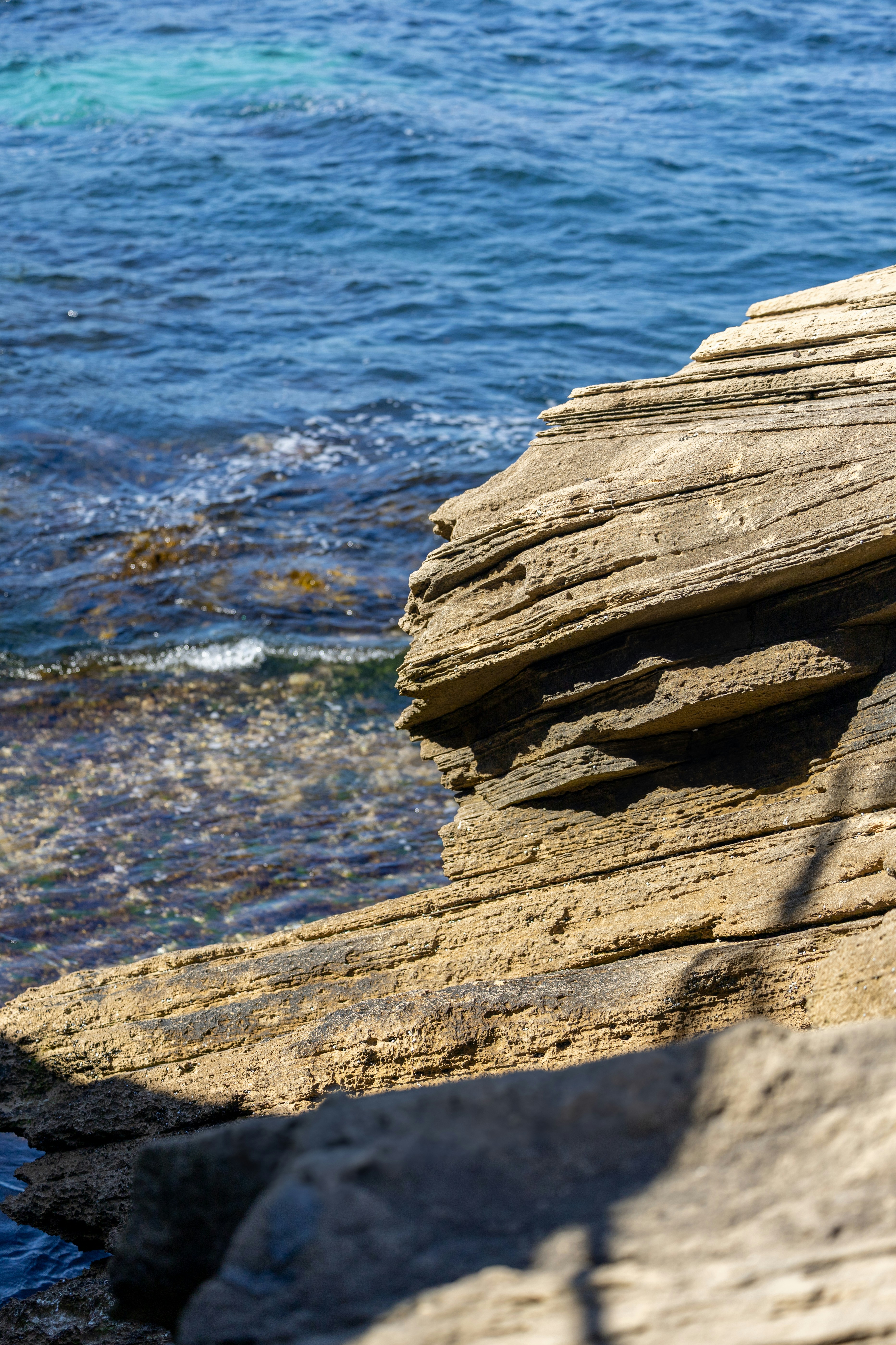 Strata by the Sea: Layered Rocks Meet Blue Depths