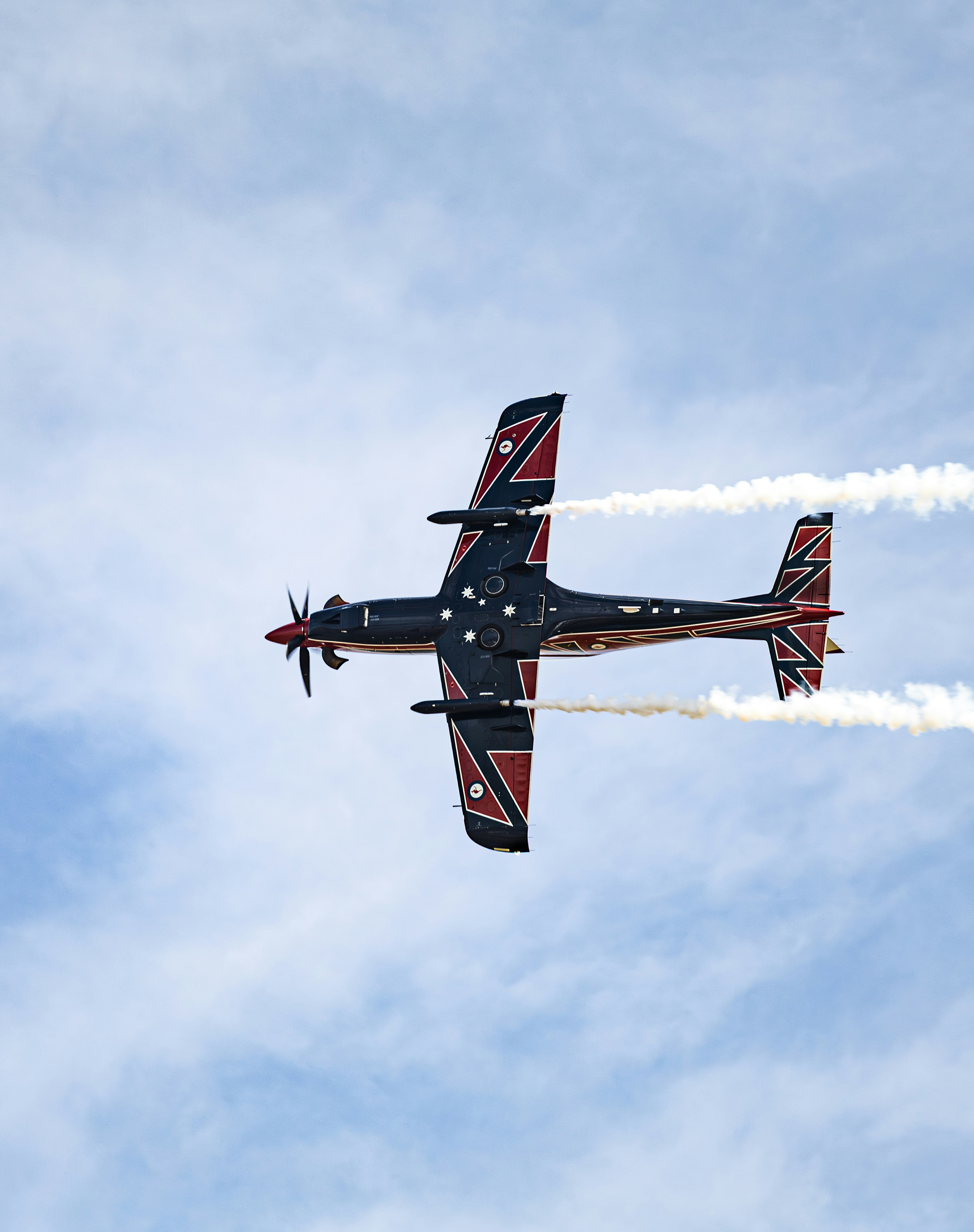 Red-White-Blue Bomber Slicing Through Sky Trails