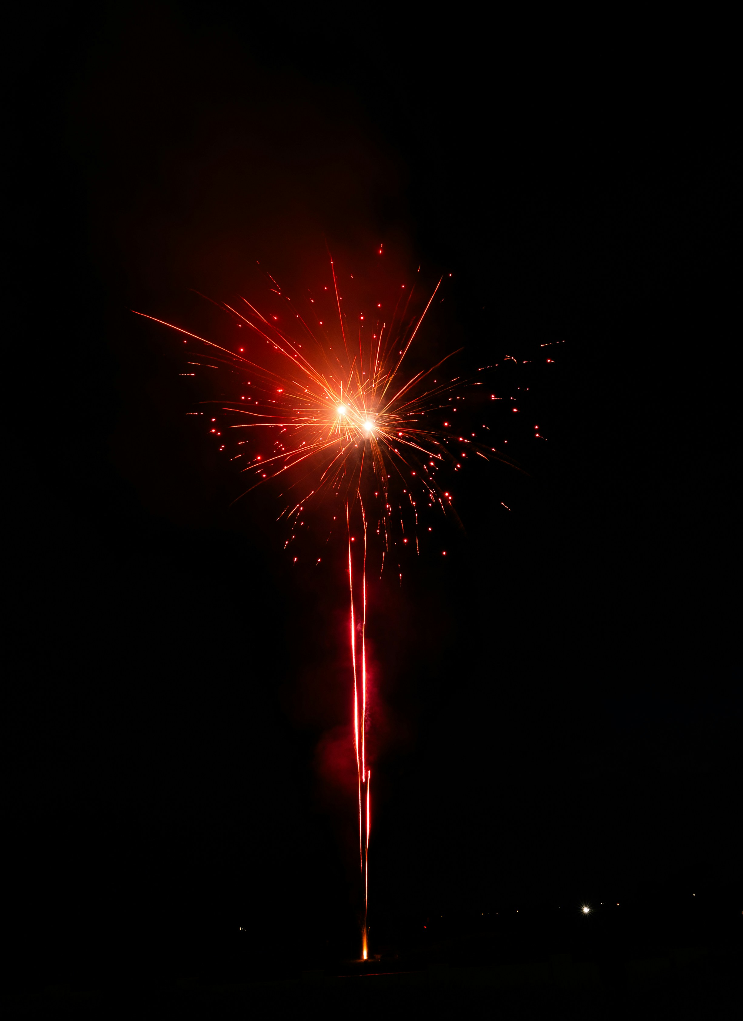 Single crimson spark leaps from the dark horizon