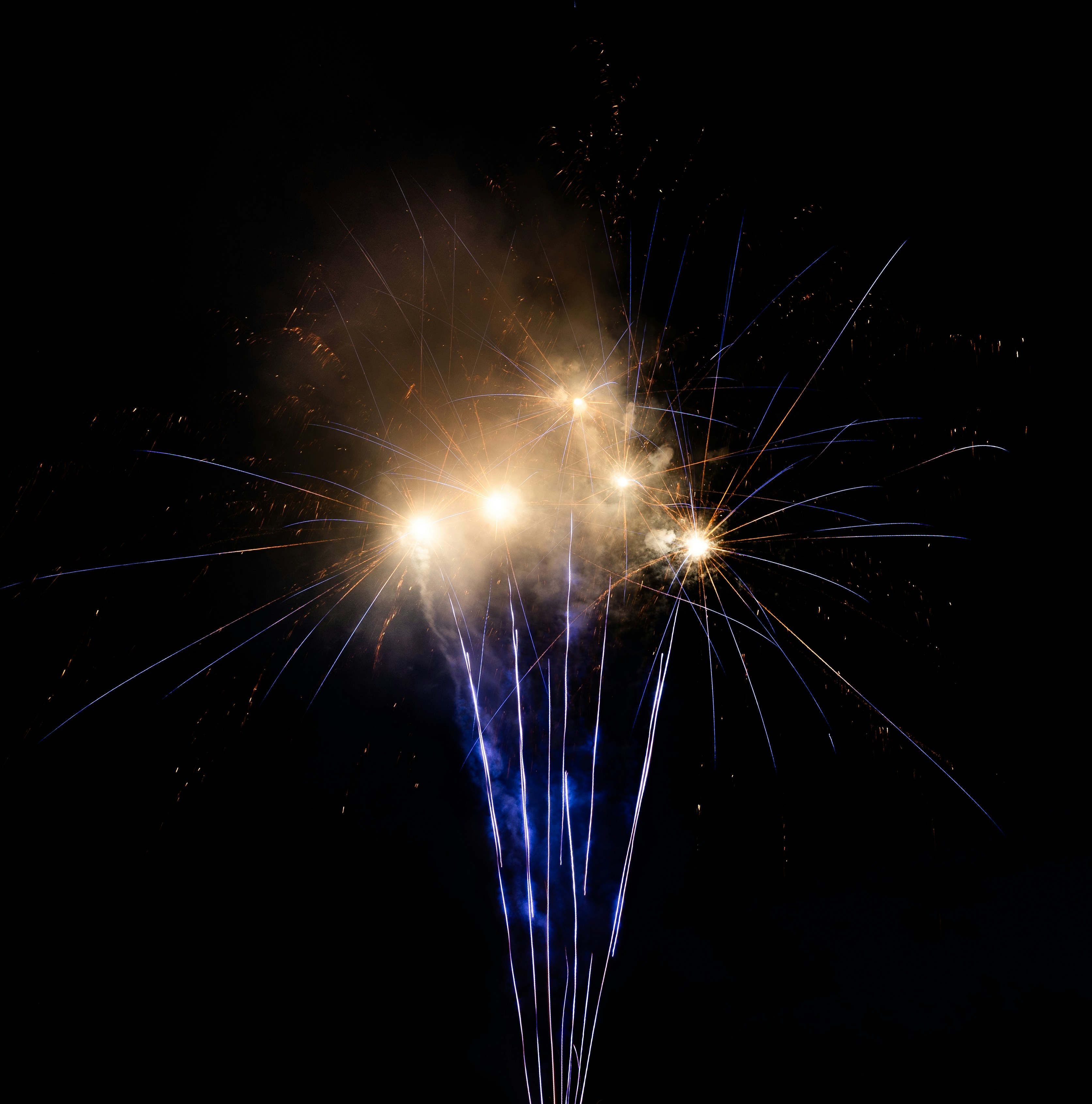 Midnight Burst: Blue Trails and Golden Orbs Illuminate the Night Sky
