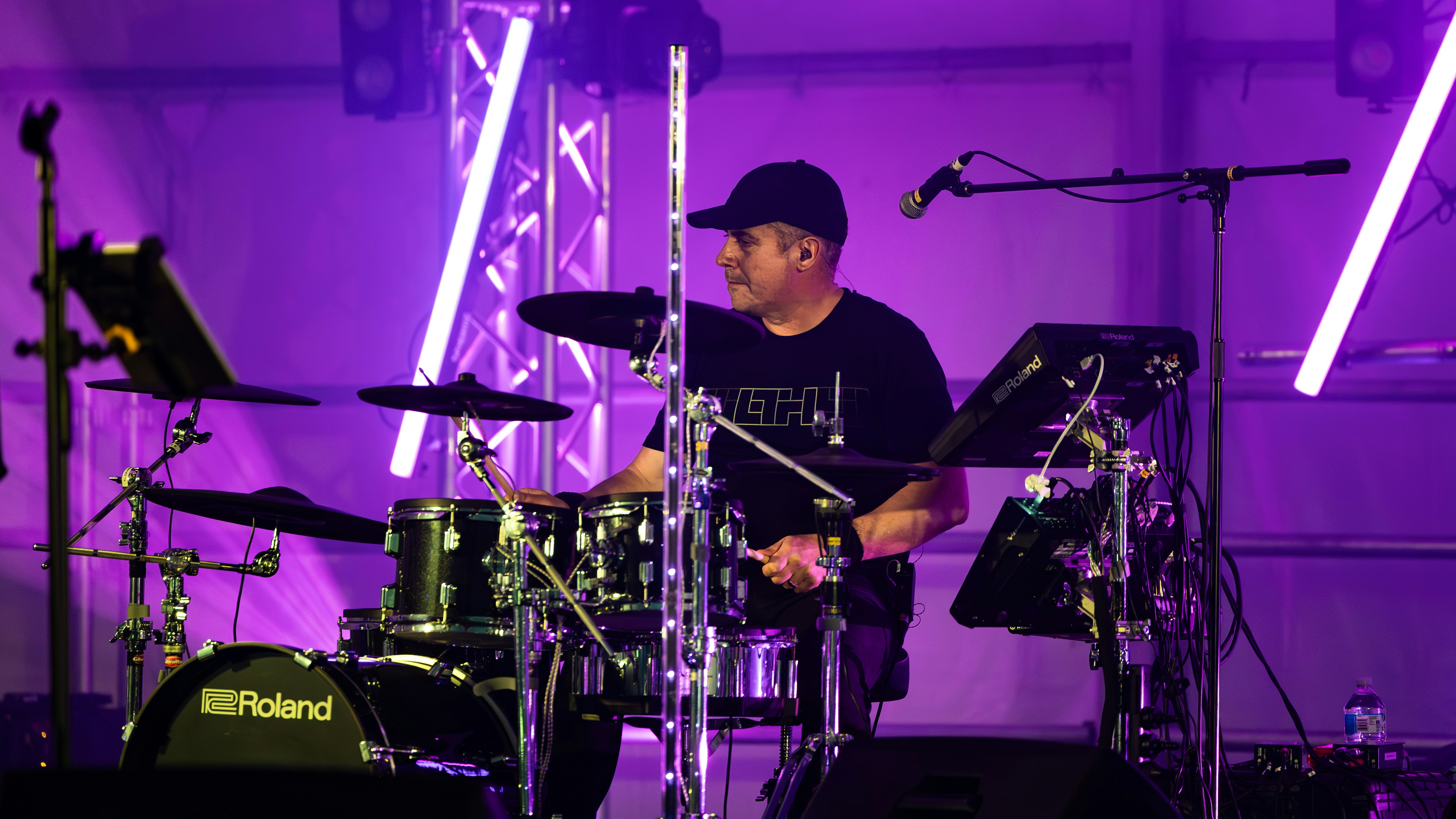 Rhythmic Focus: Drummer Steadies the Beat Under Neon Stripes