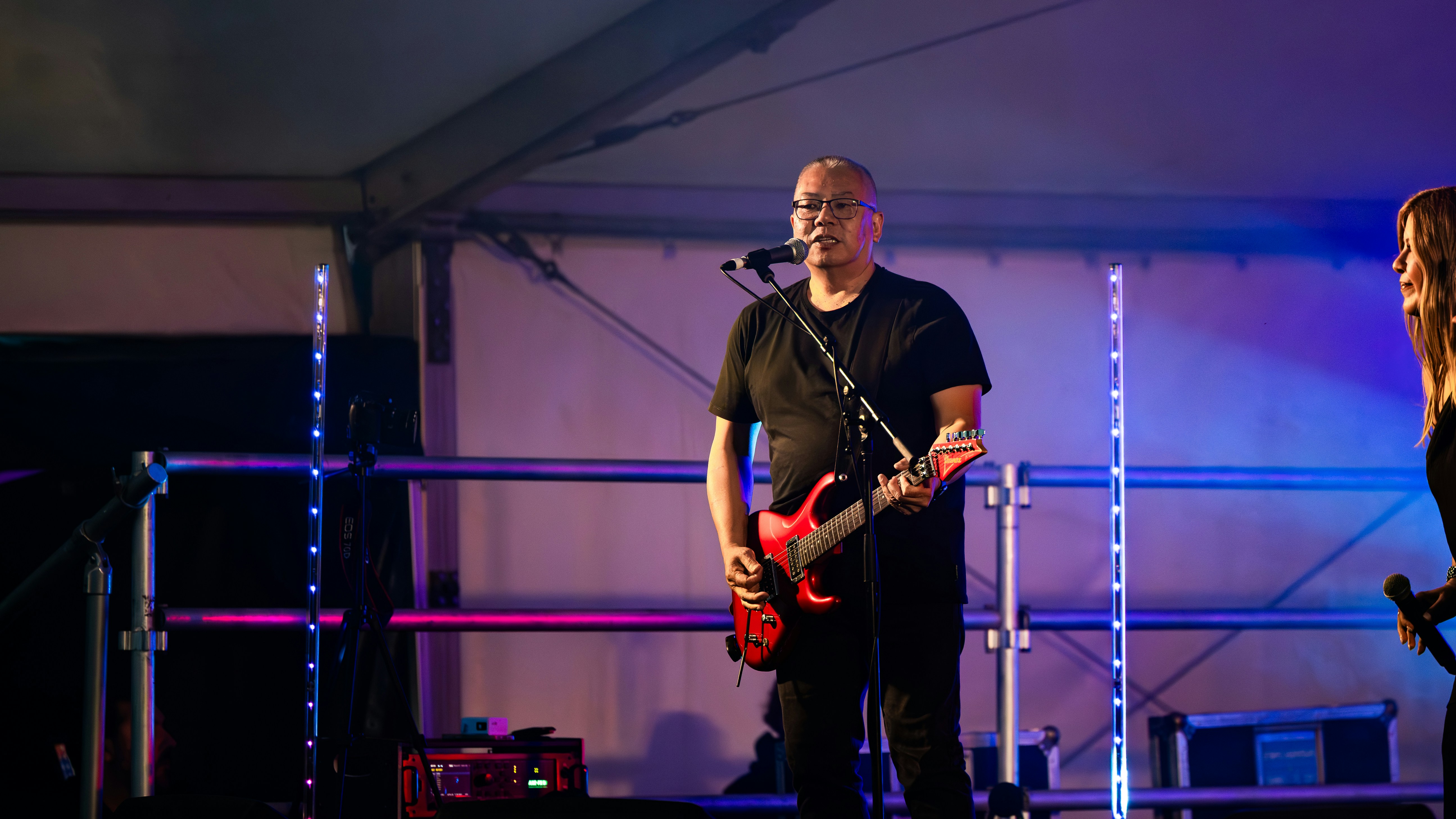 Guitarist Under Stage Lights: Quiet Focus in a Live Moment