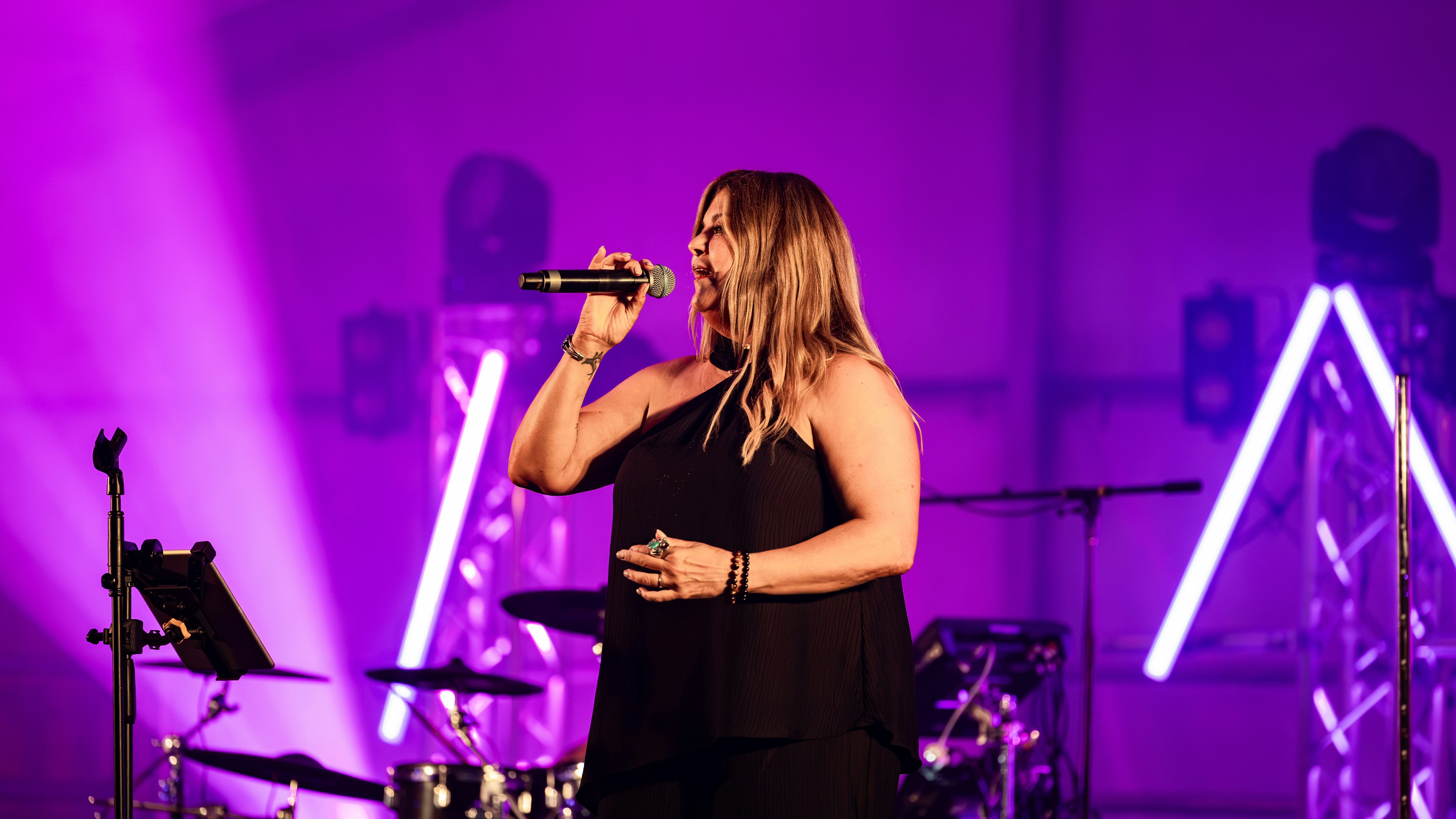 Neon-lit Solo: A vocalist anchors the stage with energy and glow