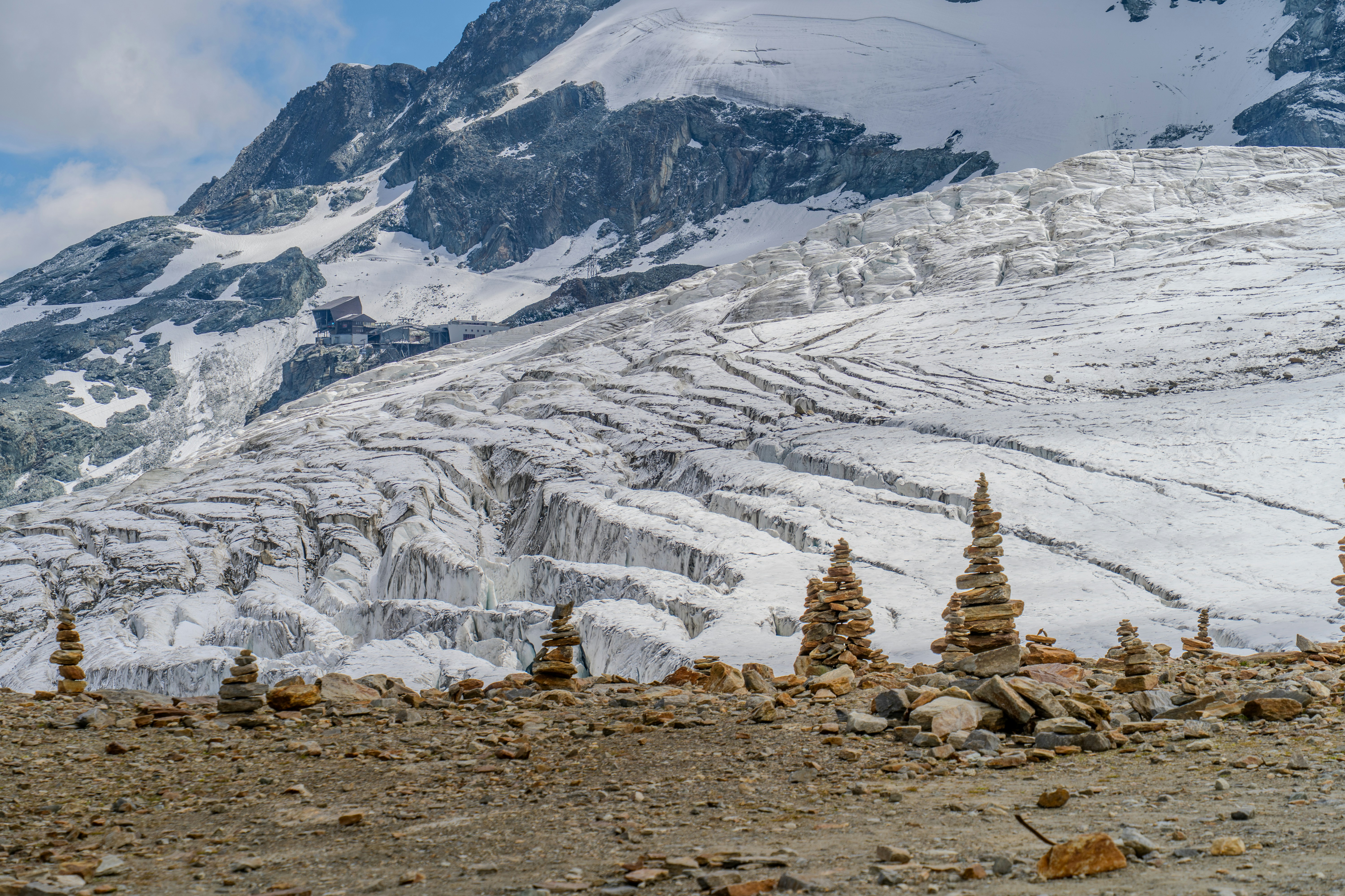 Stony cairns in the shadow of a glaciated ridge