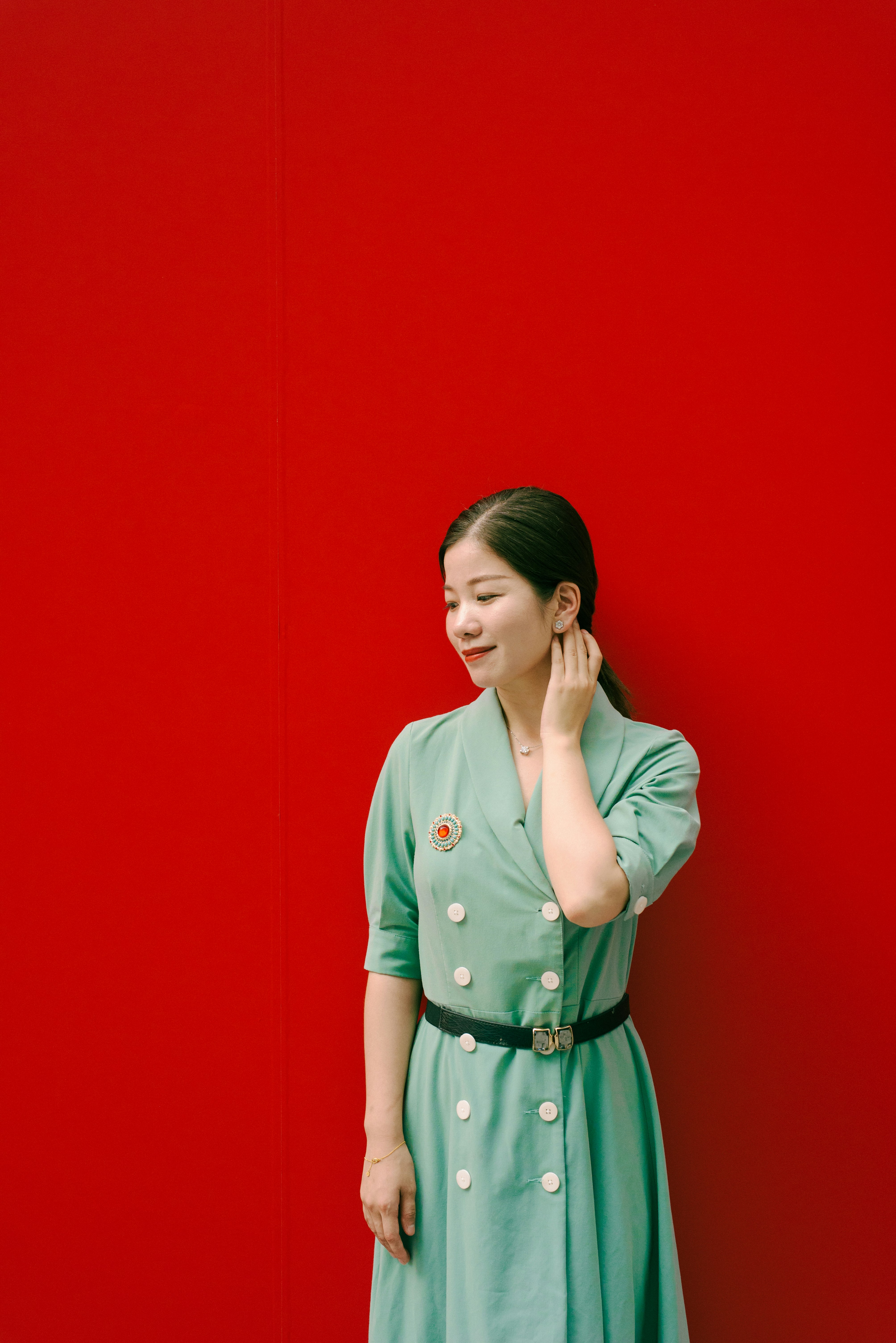 Mint-green dress against a bold red backdrop
