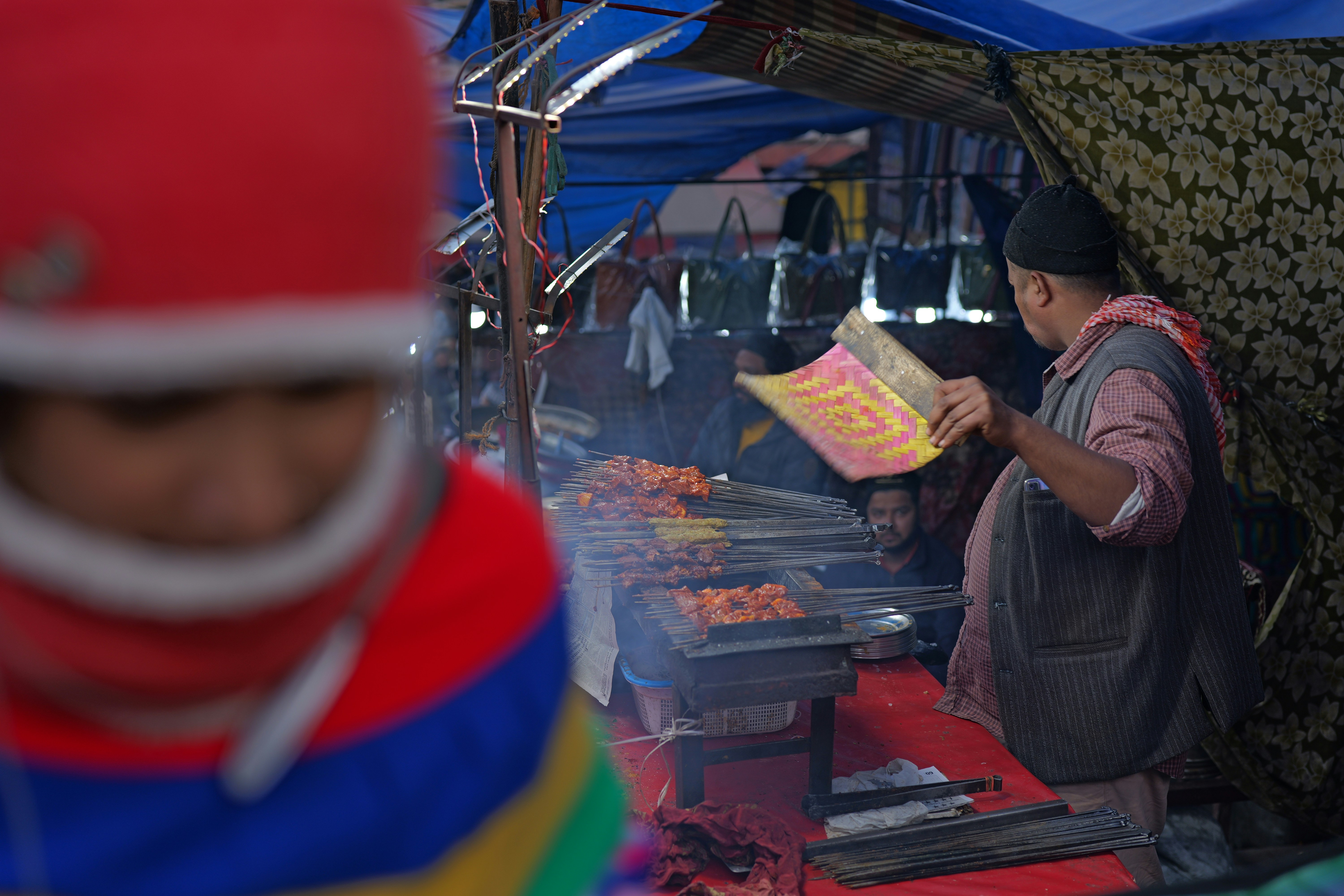 Street Vendor at a Smoke-tinged Bazaar Grilling Spices