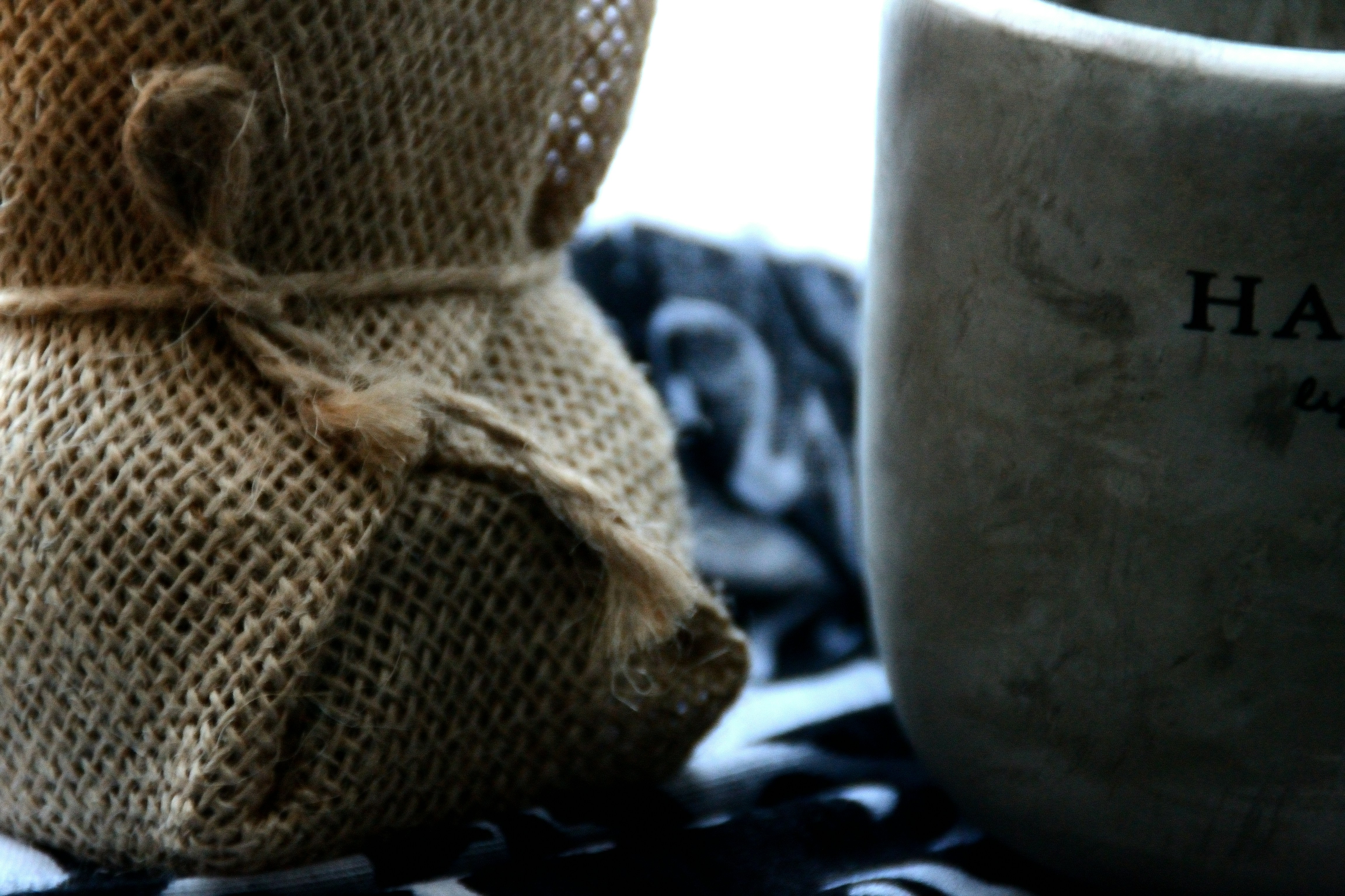 Cozy Contrast: Burlap Gift and Ceramic Cup in Soft Morning Light