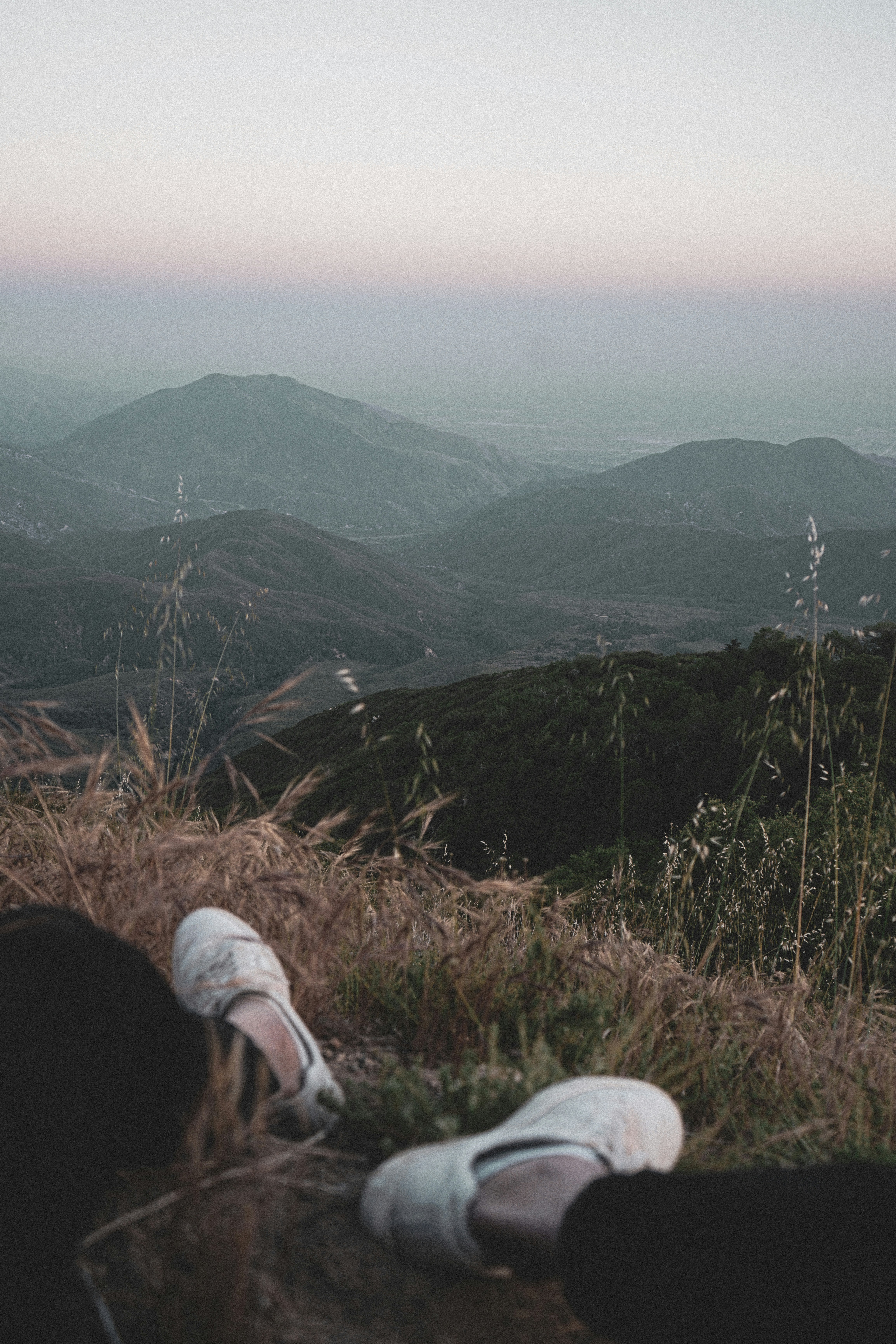 Echoes of the Hill: Feet Resting at Dusk Over Rolling Valleys