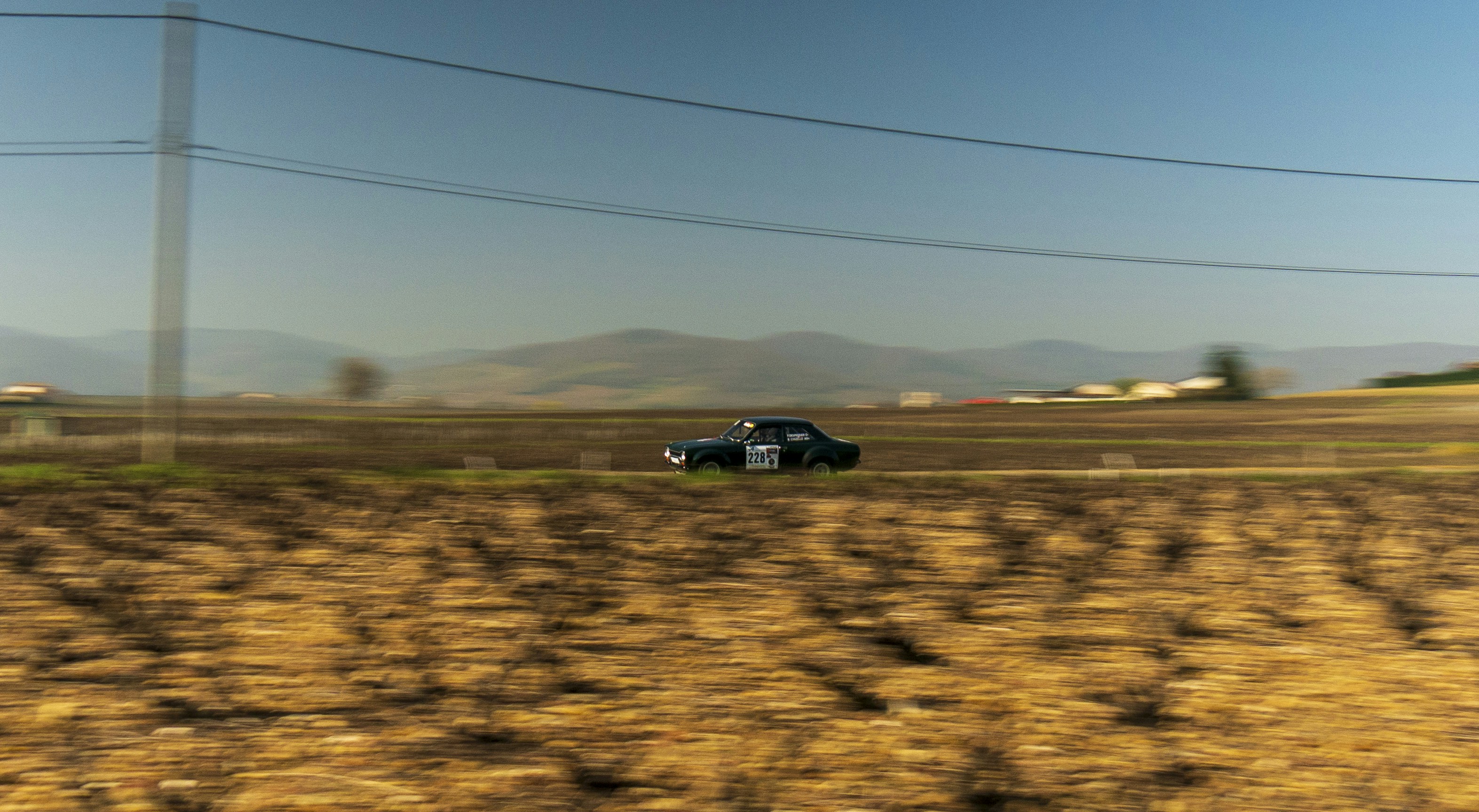 Dusty Road Chase: a Lone Car Through Golden Field