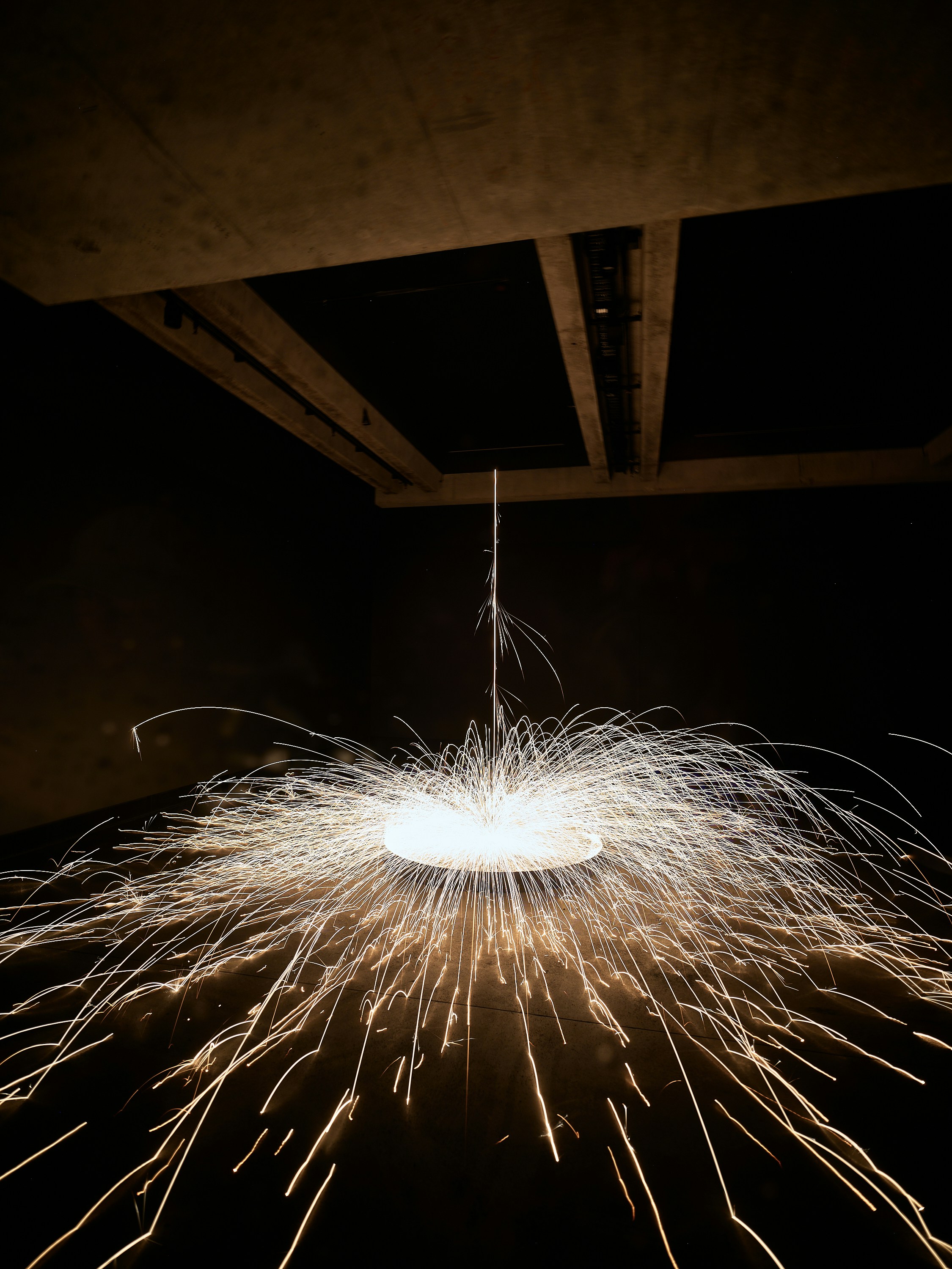 A Ring of Fire: Steel Wool Sparks Against a Dark Ceiling