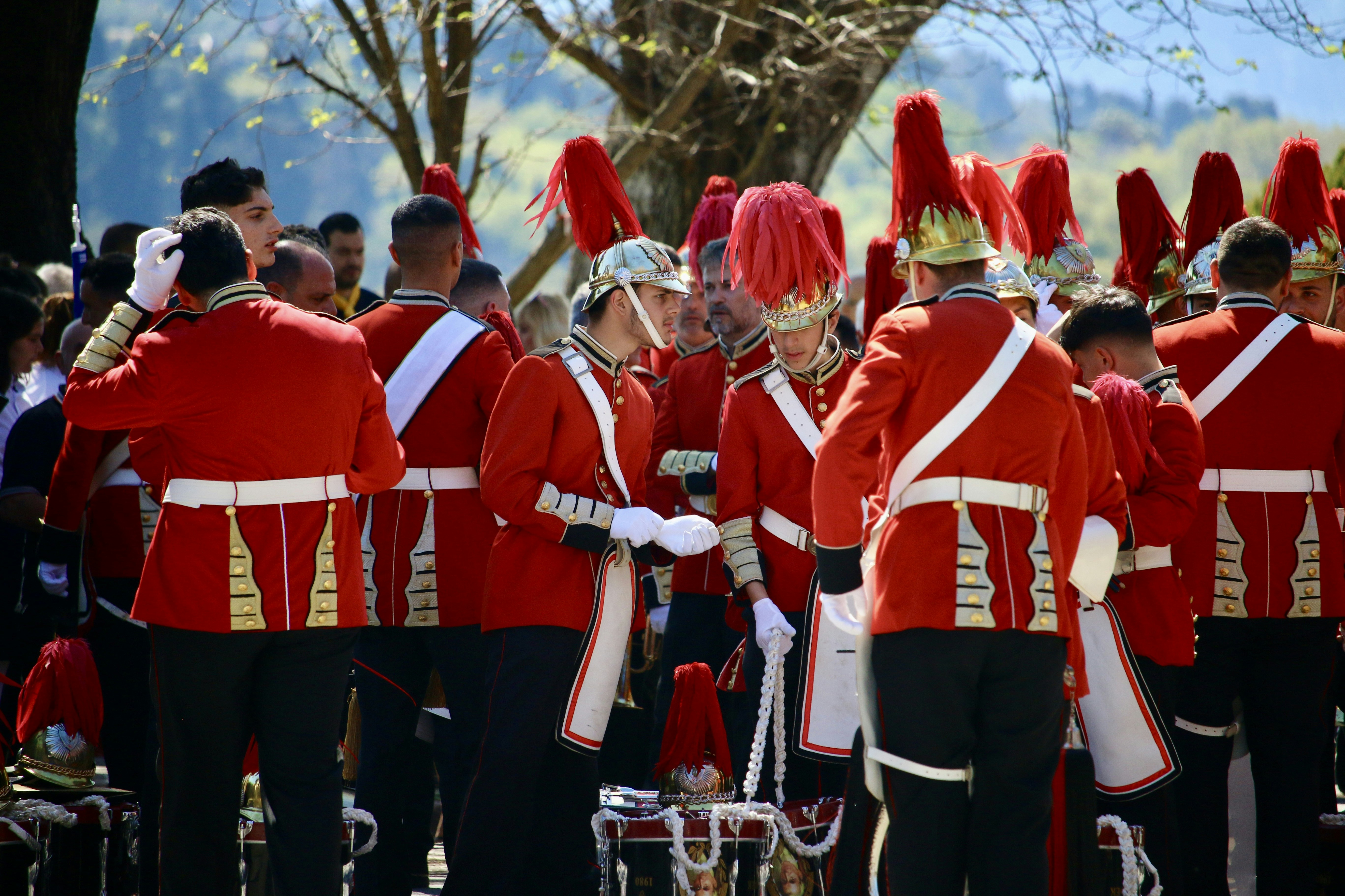 Scarlet Parade: Officers in Red Ceremonial Attire Amidst a Tense Circle