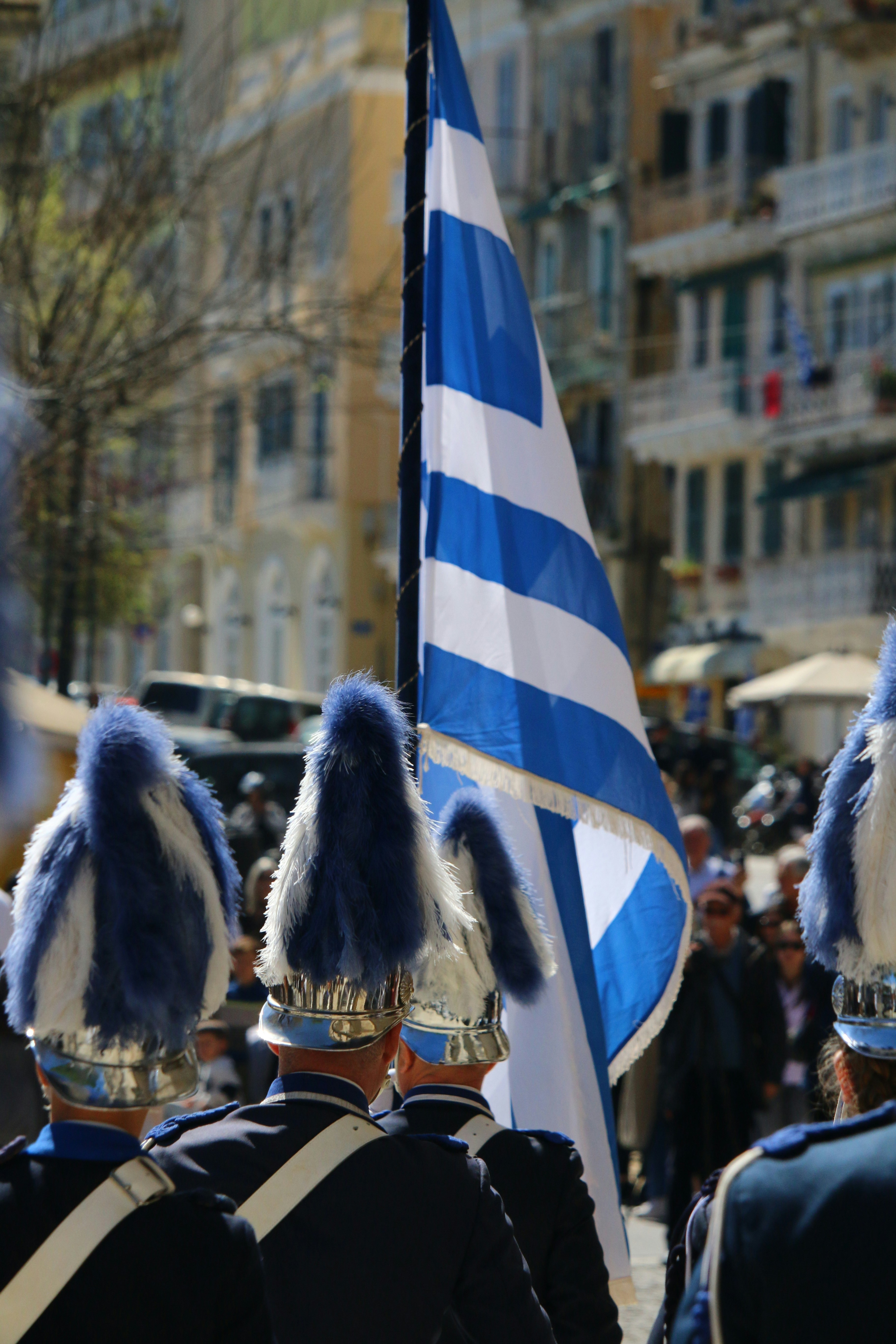 Blue-and-White Parade Standard: Flags and Plumes Framed by City Facades