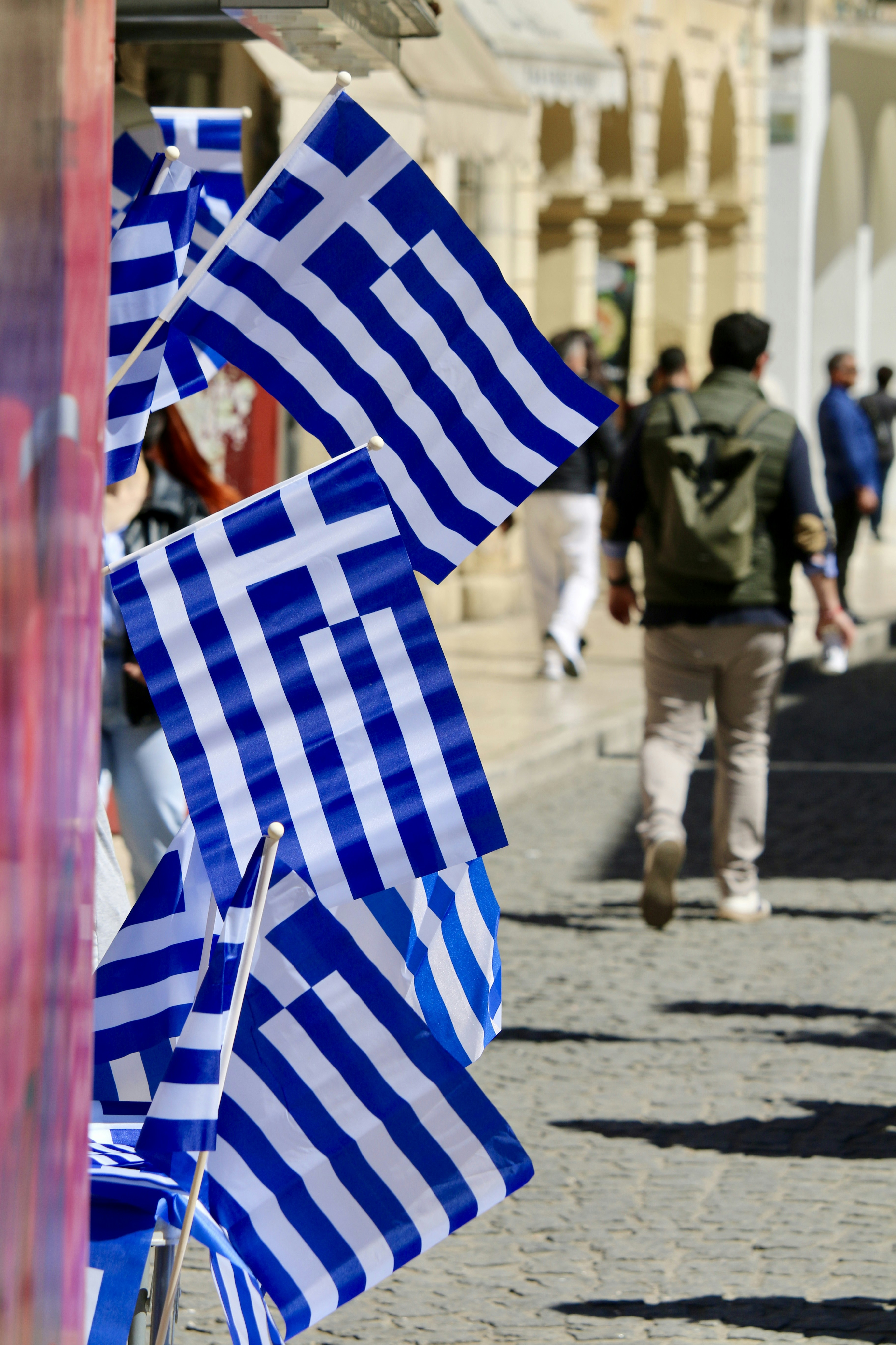 Blue and White Flags Line a Sunlit Street Market