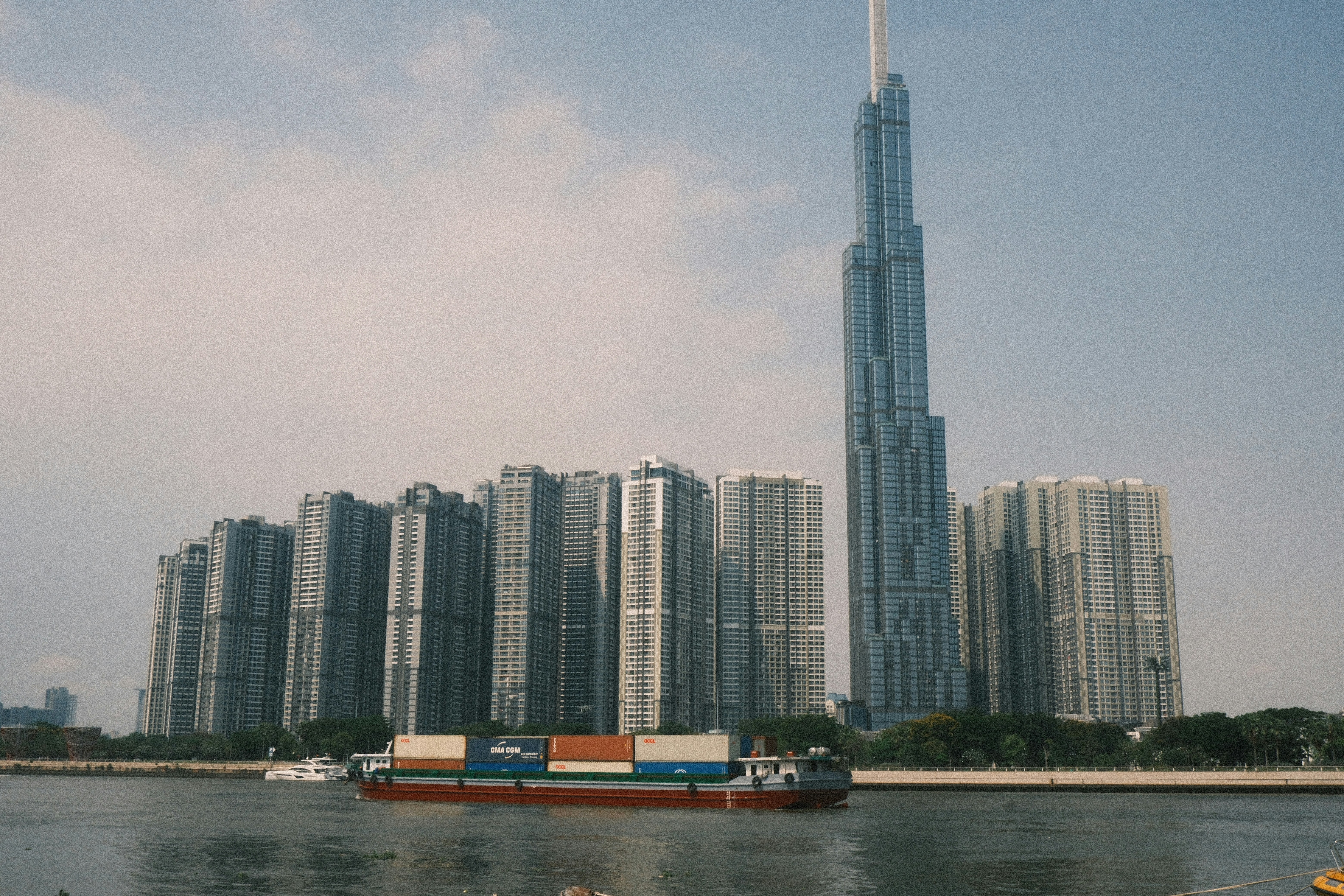 Riverfront Skyscrapers and Cargo Barge: Dubai's Modern Silhouette