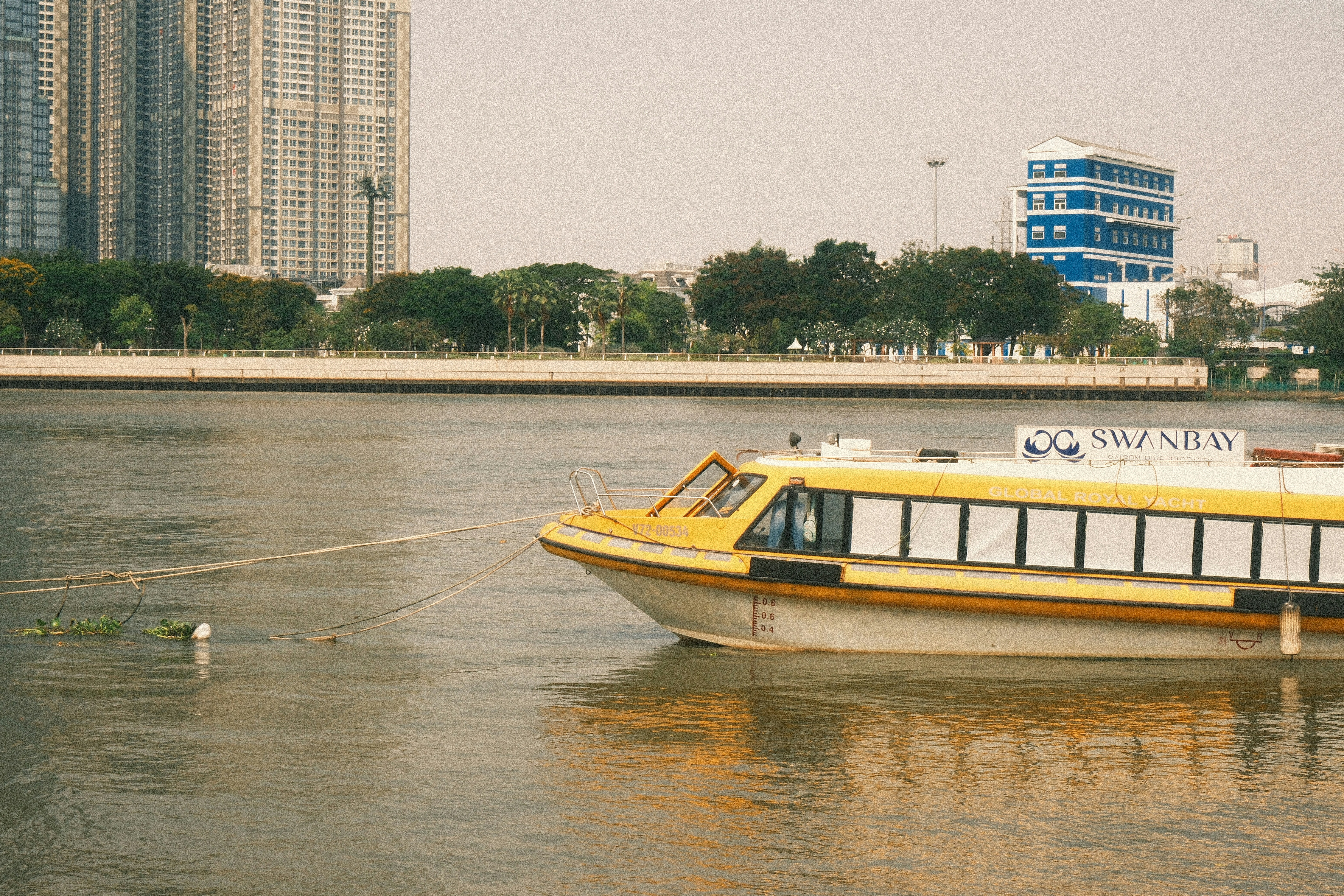 Golden-hued river taxi drifting by a cityscape