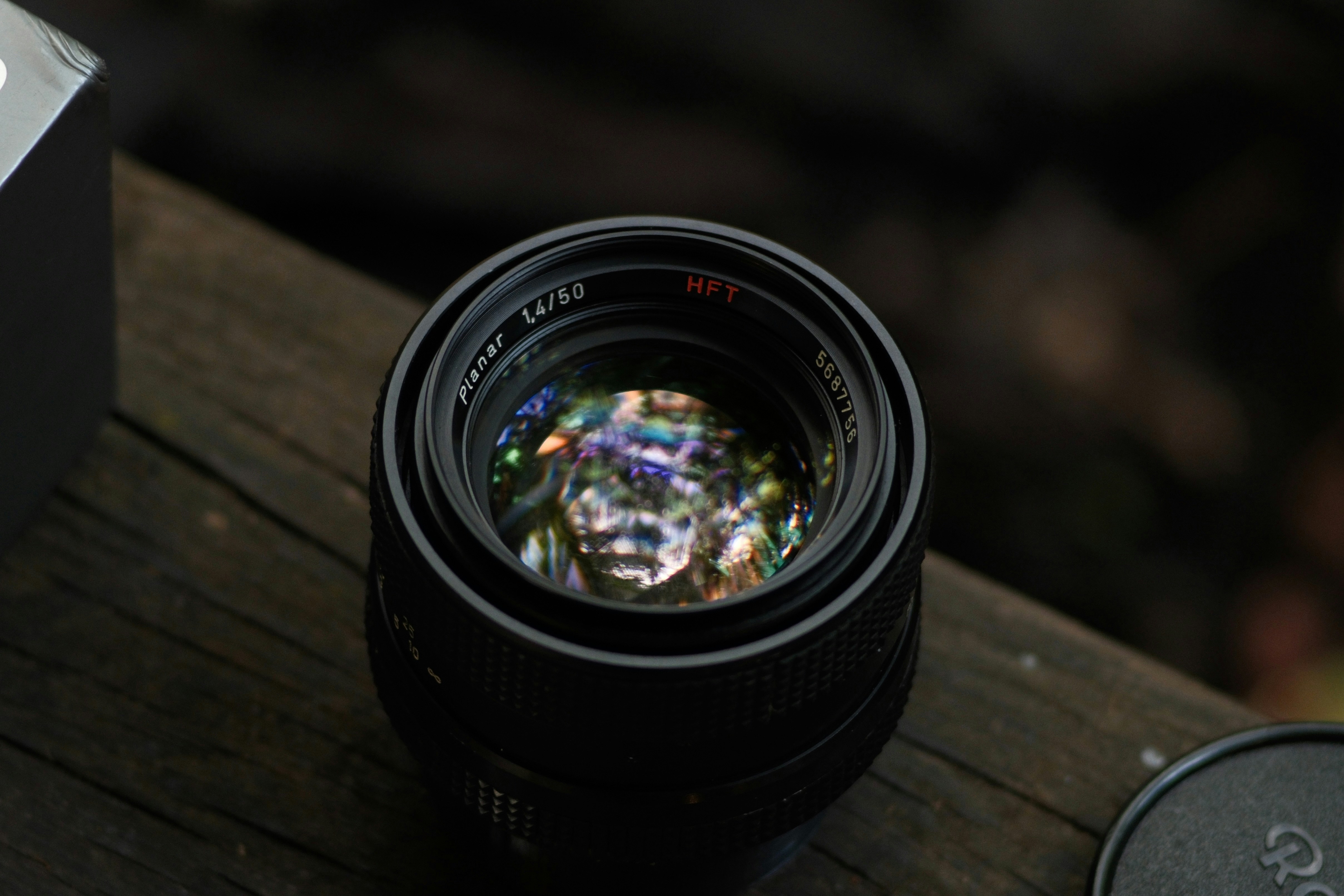 Reflections in a Vintage Lens: A Close-Up of a Black Prime on a Wooden Deck