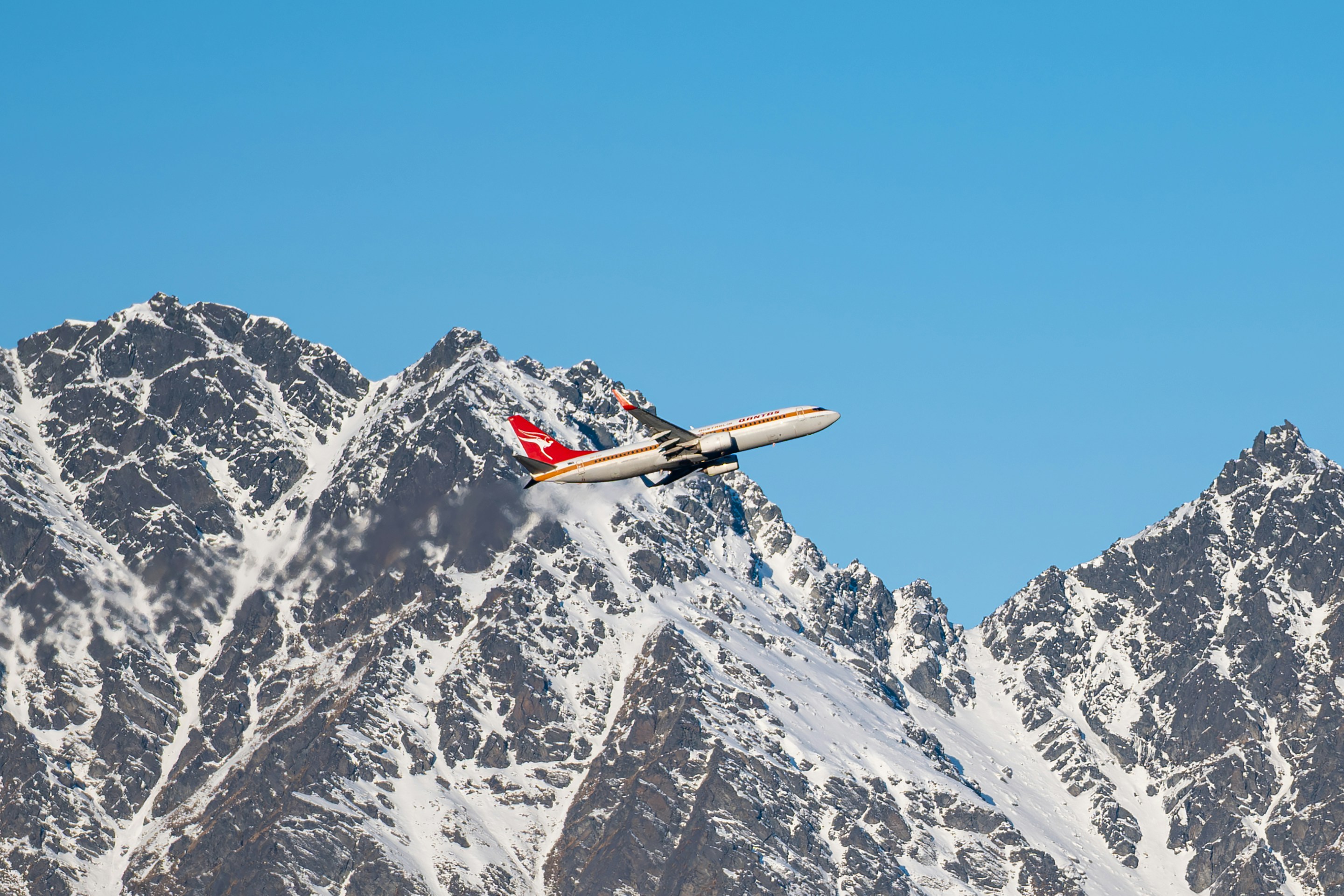 Air over the Wraith Peaks: A lone jet climbs past jagged snow