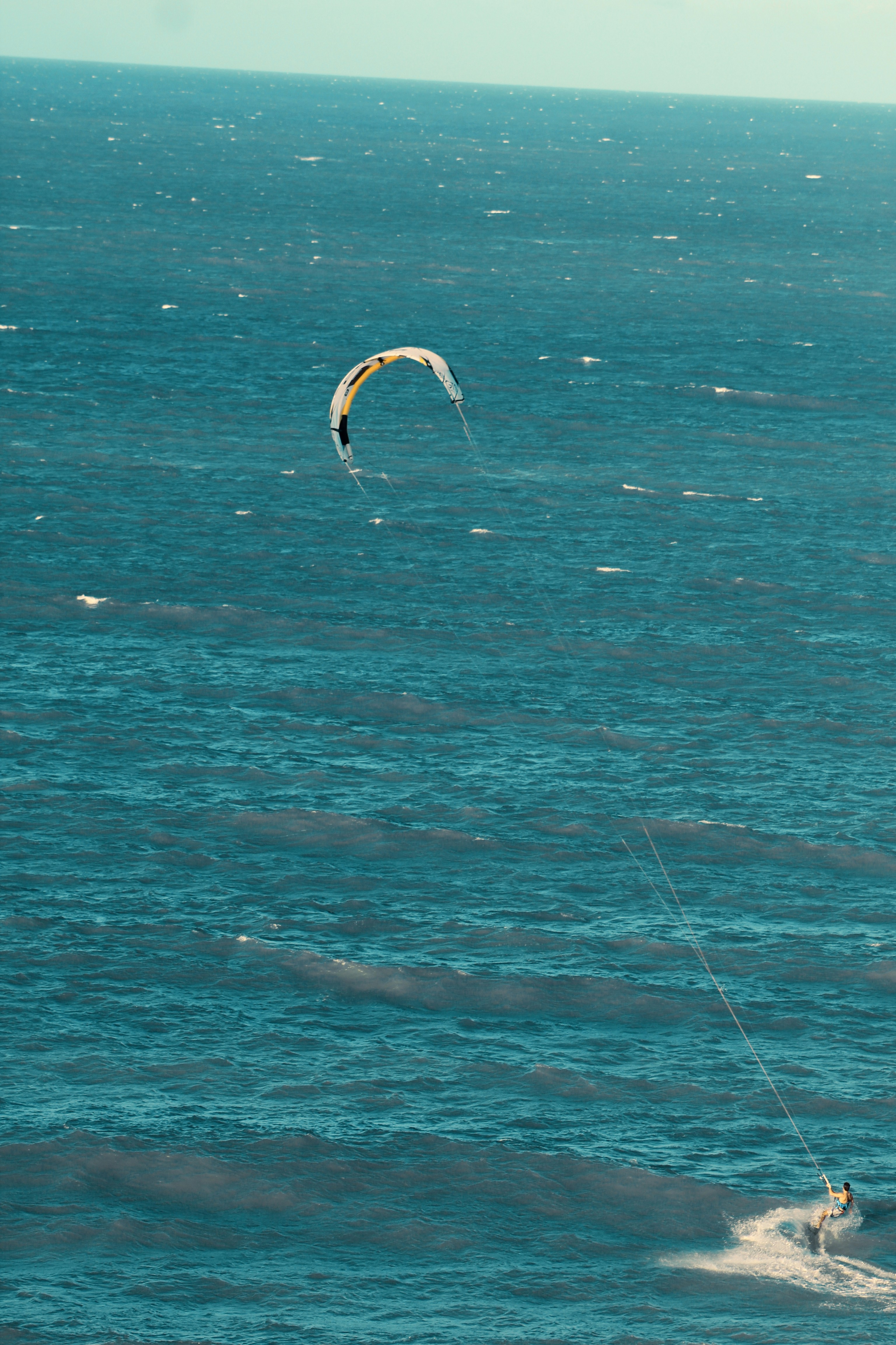Kiteflight over Teal Expanse: A lone rider carves a wake
