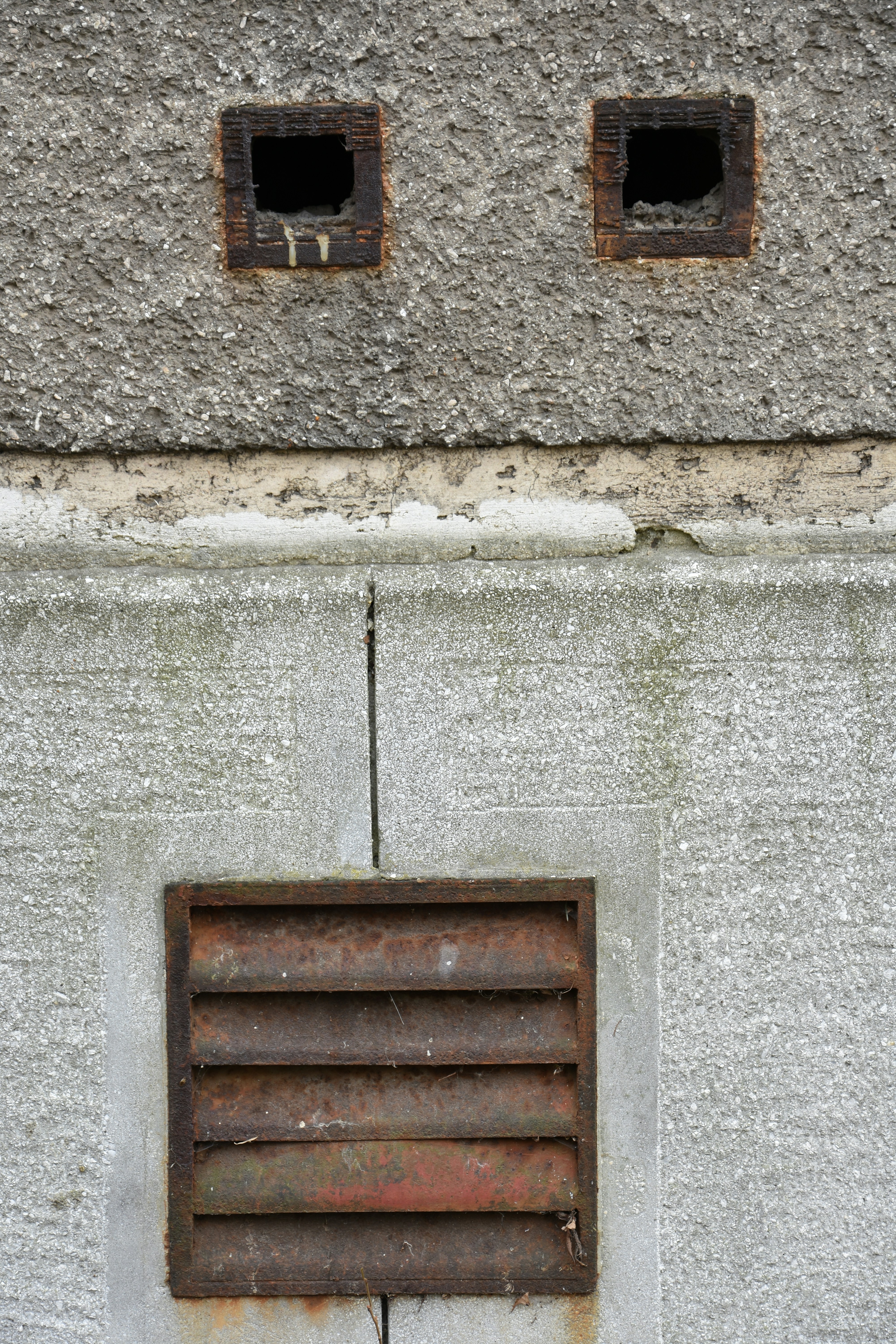 Rusty vents on a weathered concrete facade