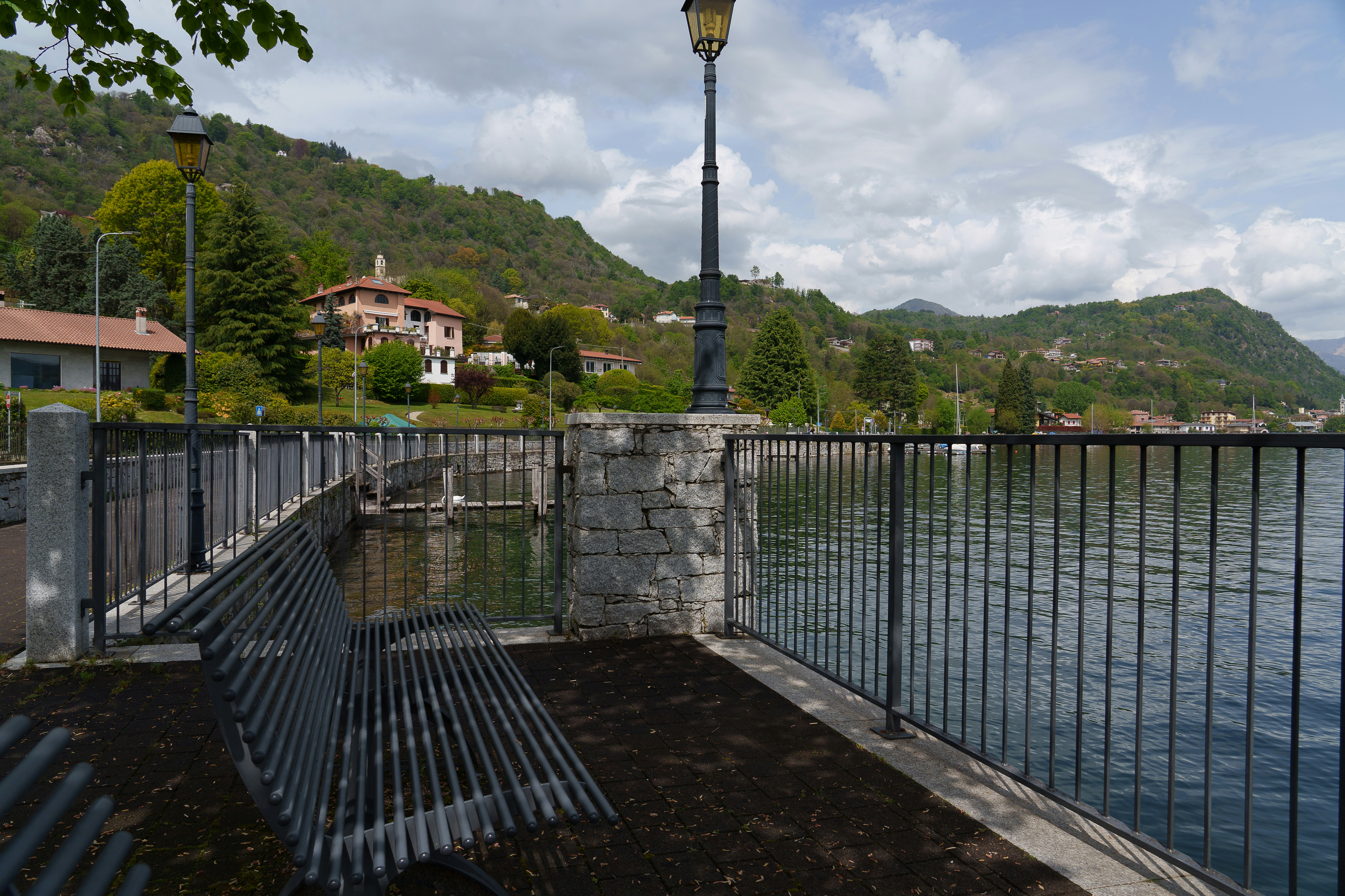 Quiet Lakeside Promenade with Rustic Bench and Lamp
