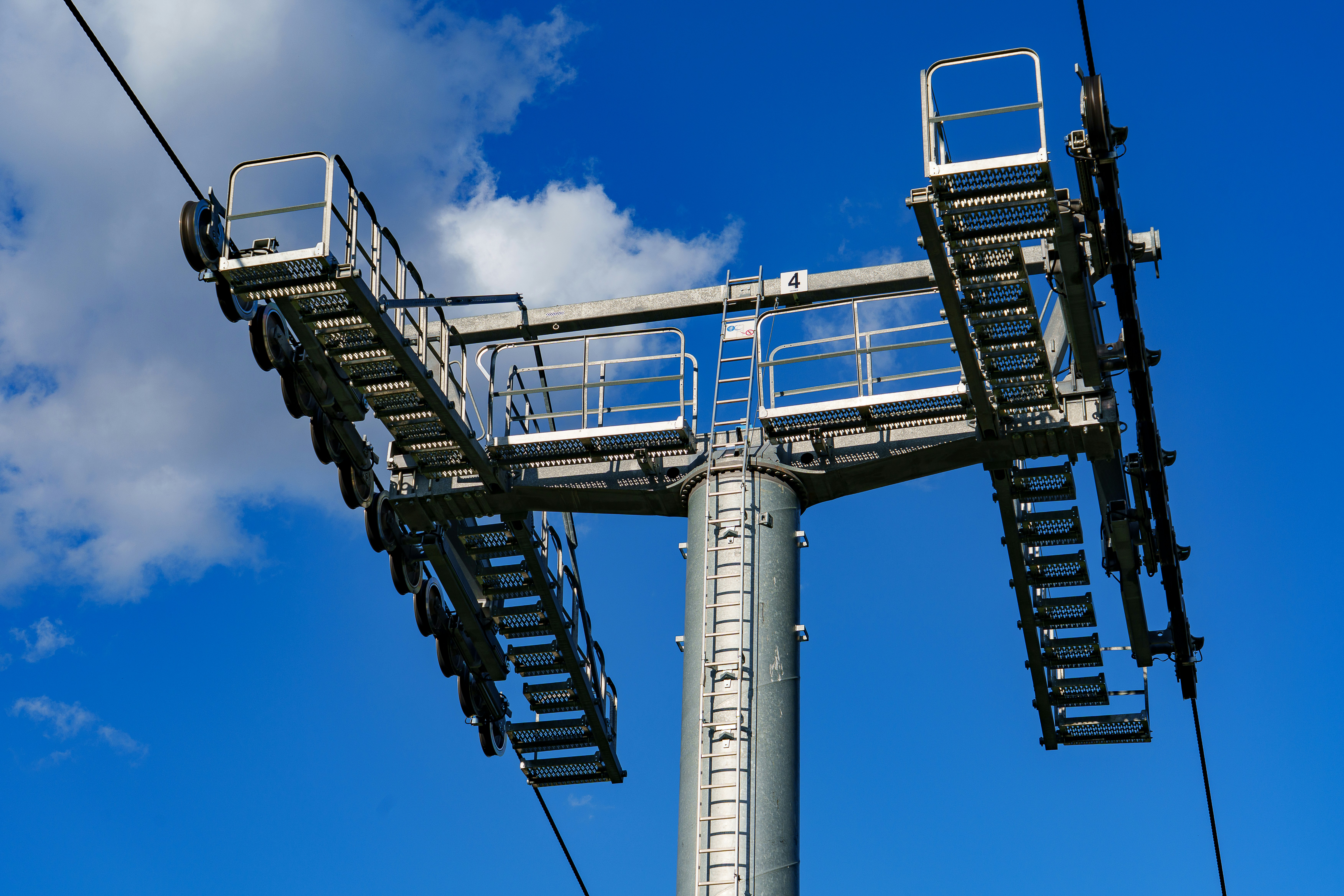 Cabled Summit: A Laddered Crossing Against a Cerulean Sky