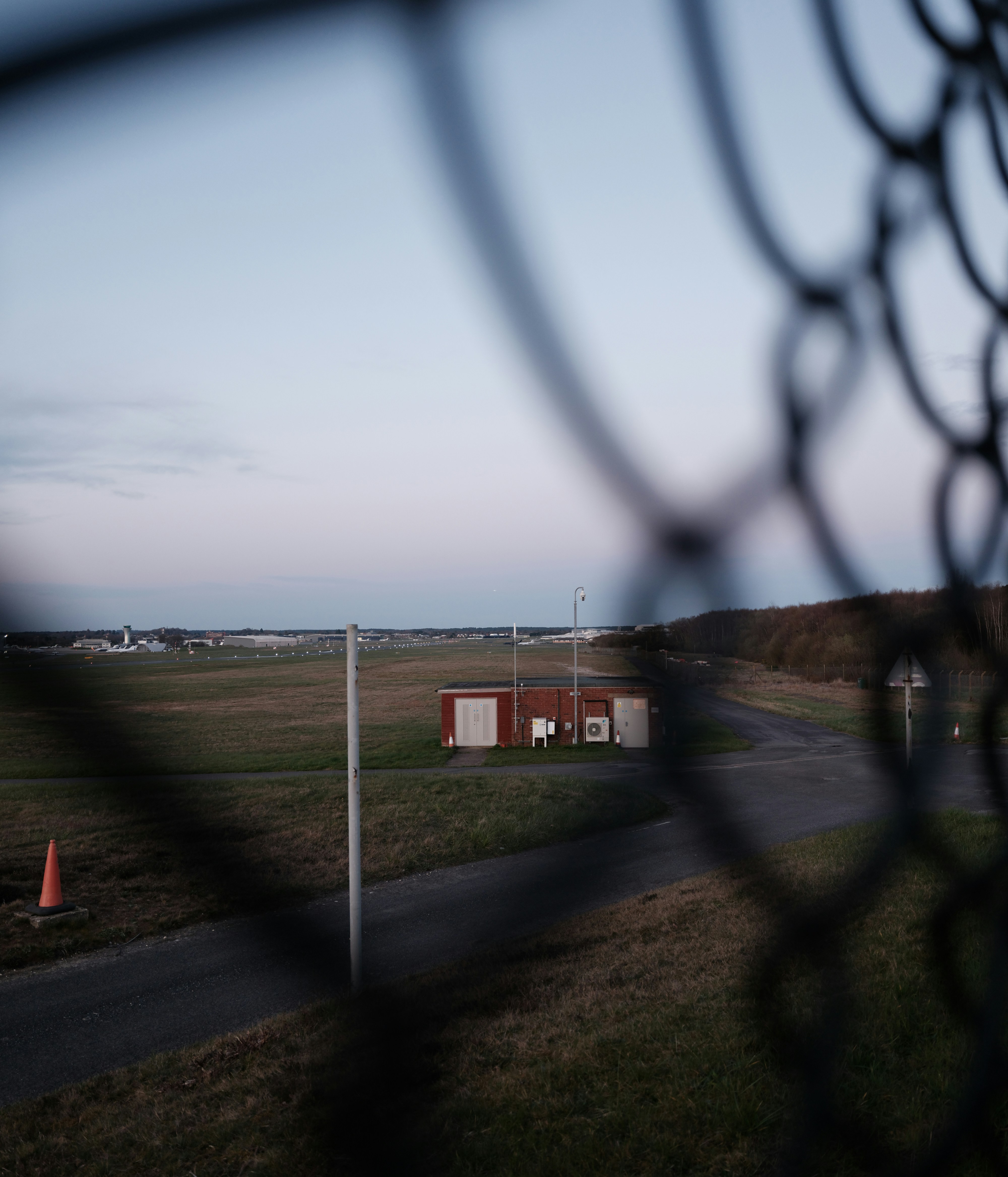 Breached Fence: horizon framed by out-of-focus ringed barrier