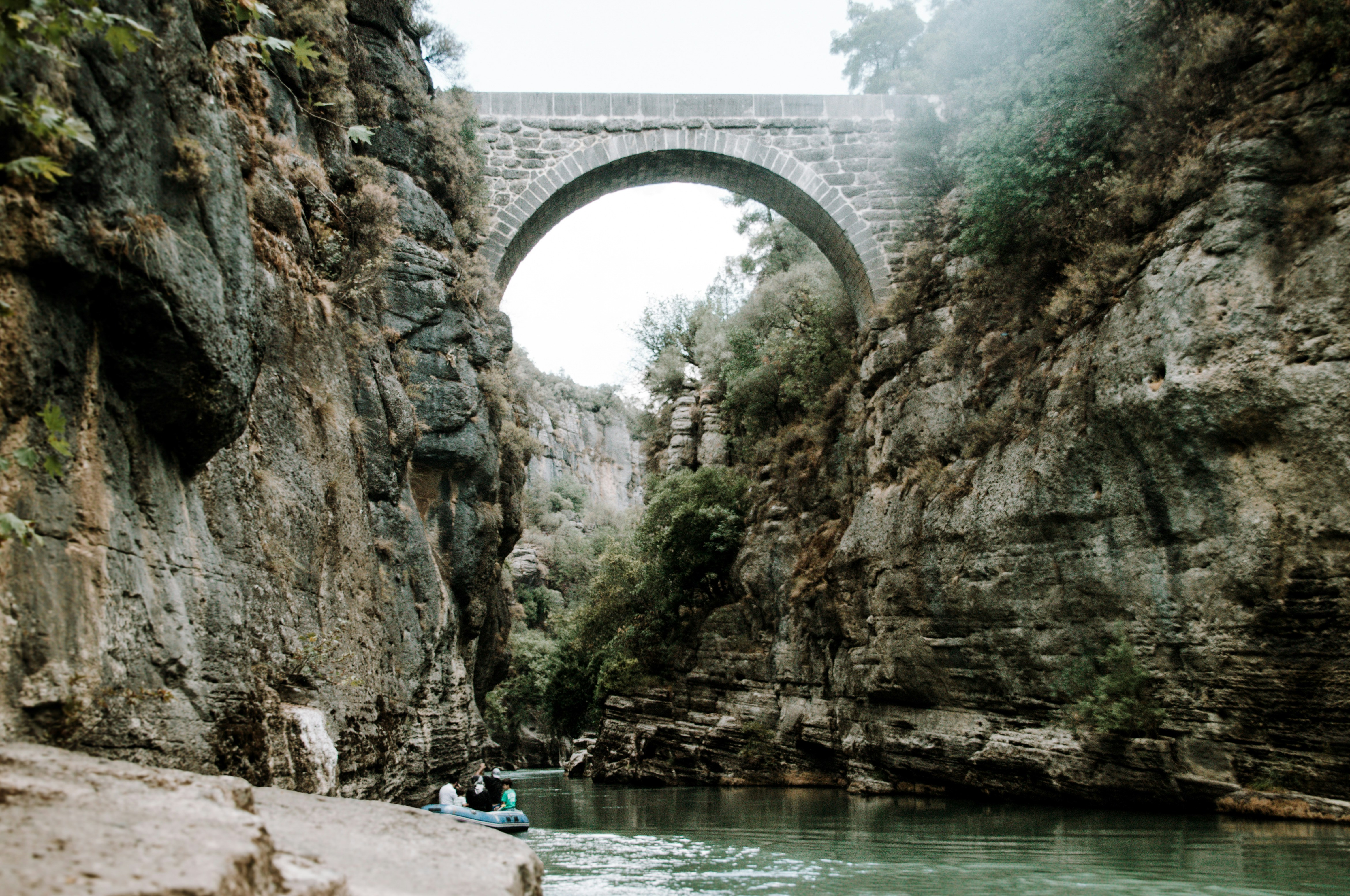 Stone Arch Over River: Canyon Bridge Framed by Narrow Gorge