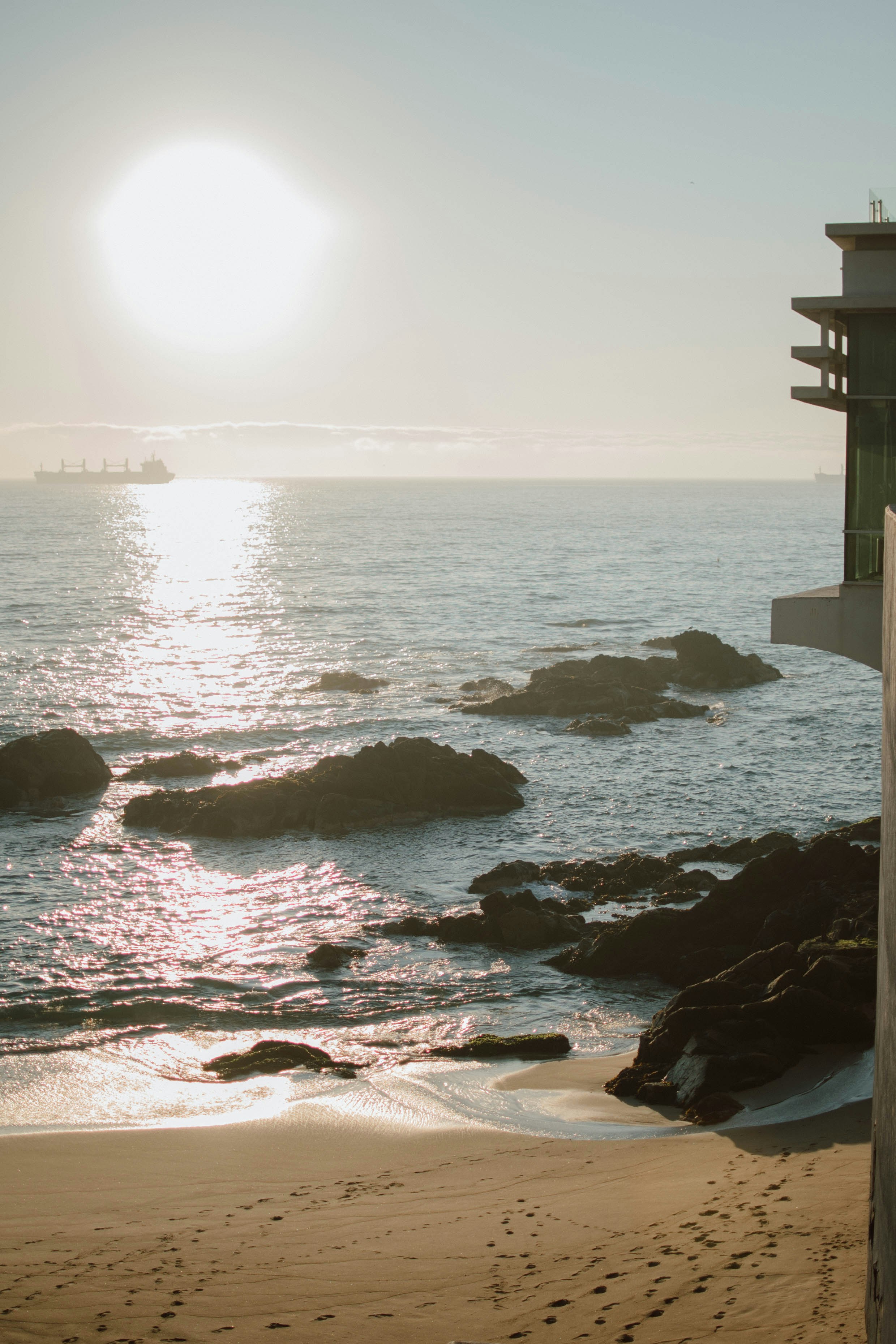 Sunlit Coastal Vista with Rock Outcrops and Modern Groynes