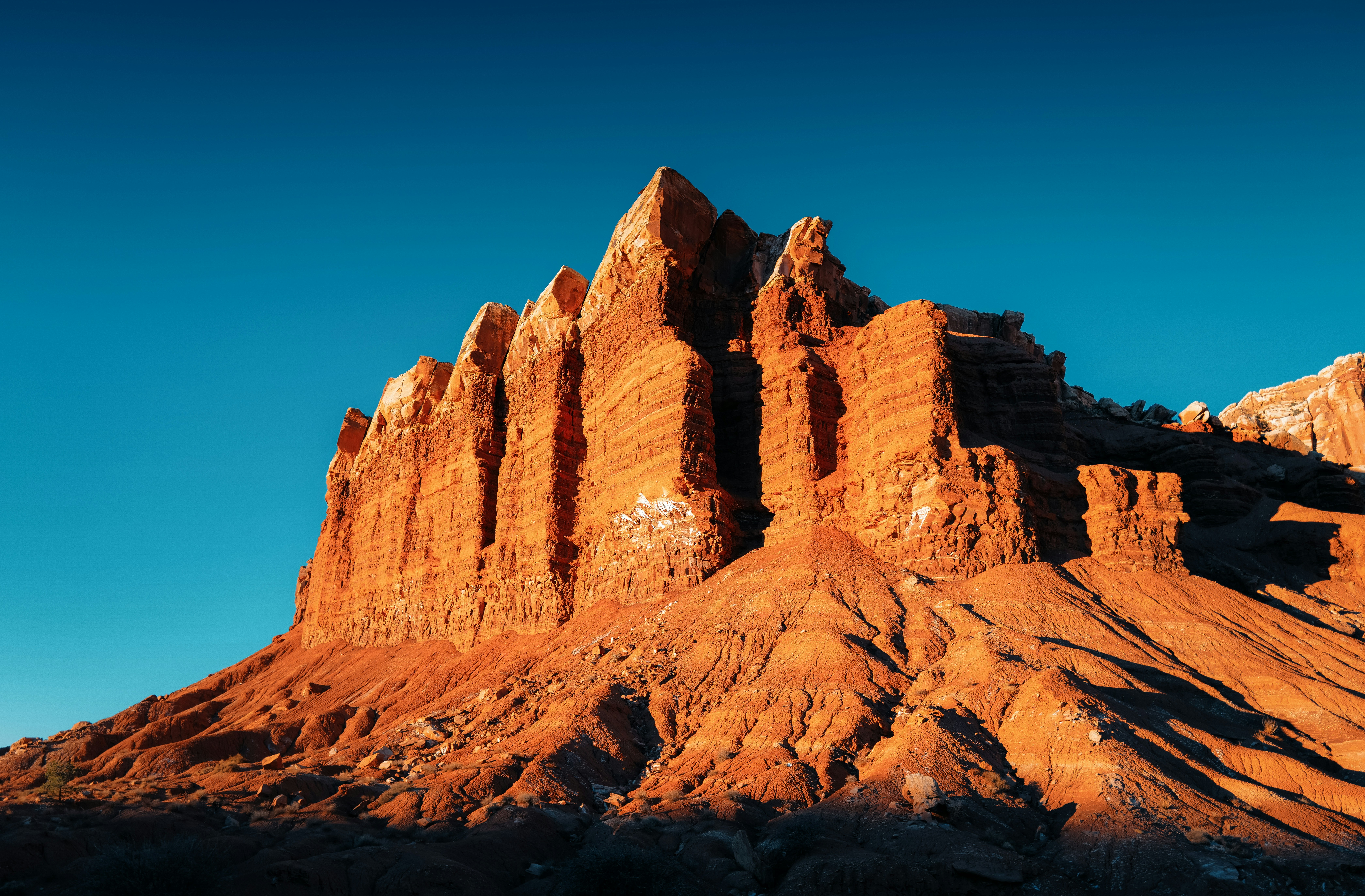 Sunlit Carved Fins: A Red Rock Colossus Under a Clear Blue Sky