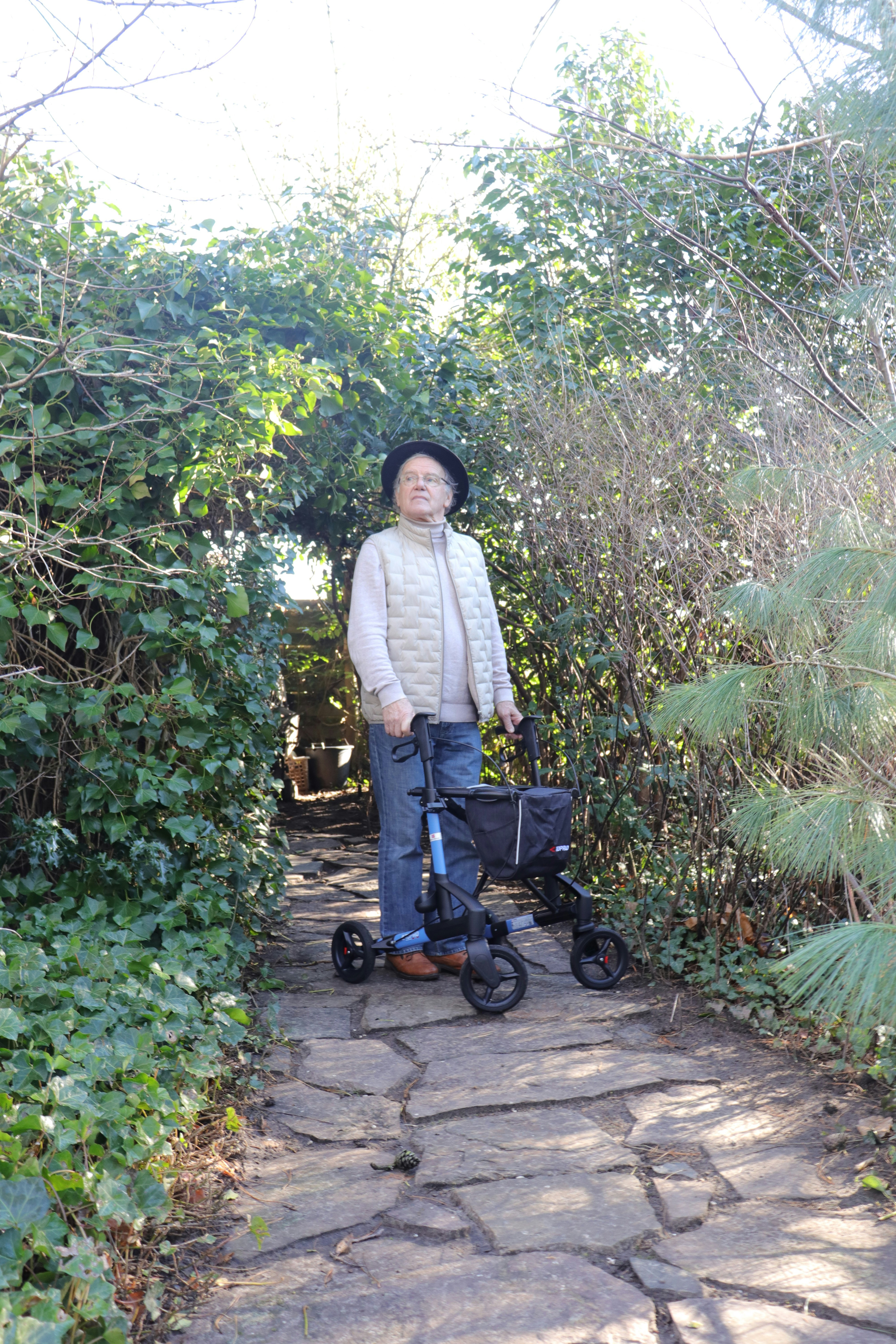 Gardener on a Stone Path: An Elderly Caregiver in a Shaded Garden
