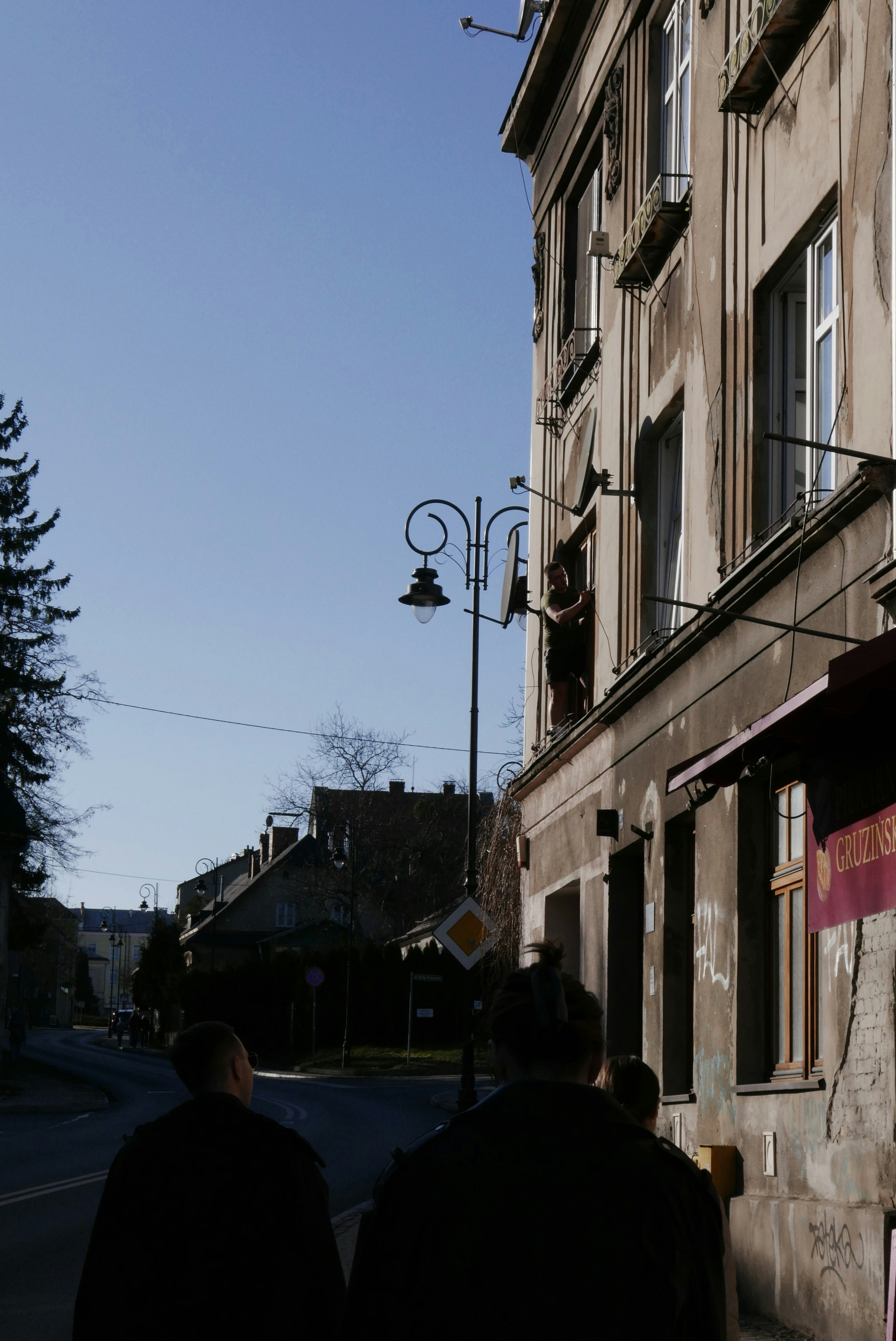 Facade Climber: A Rueful Moment on a Sunlit Street