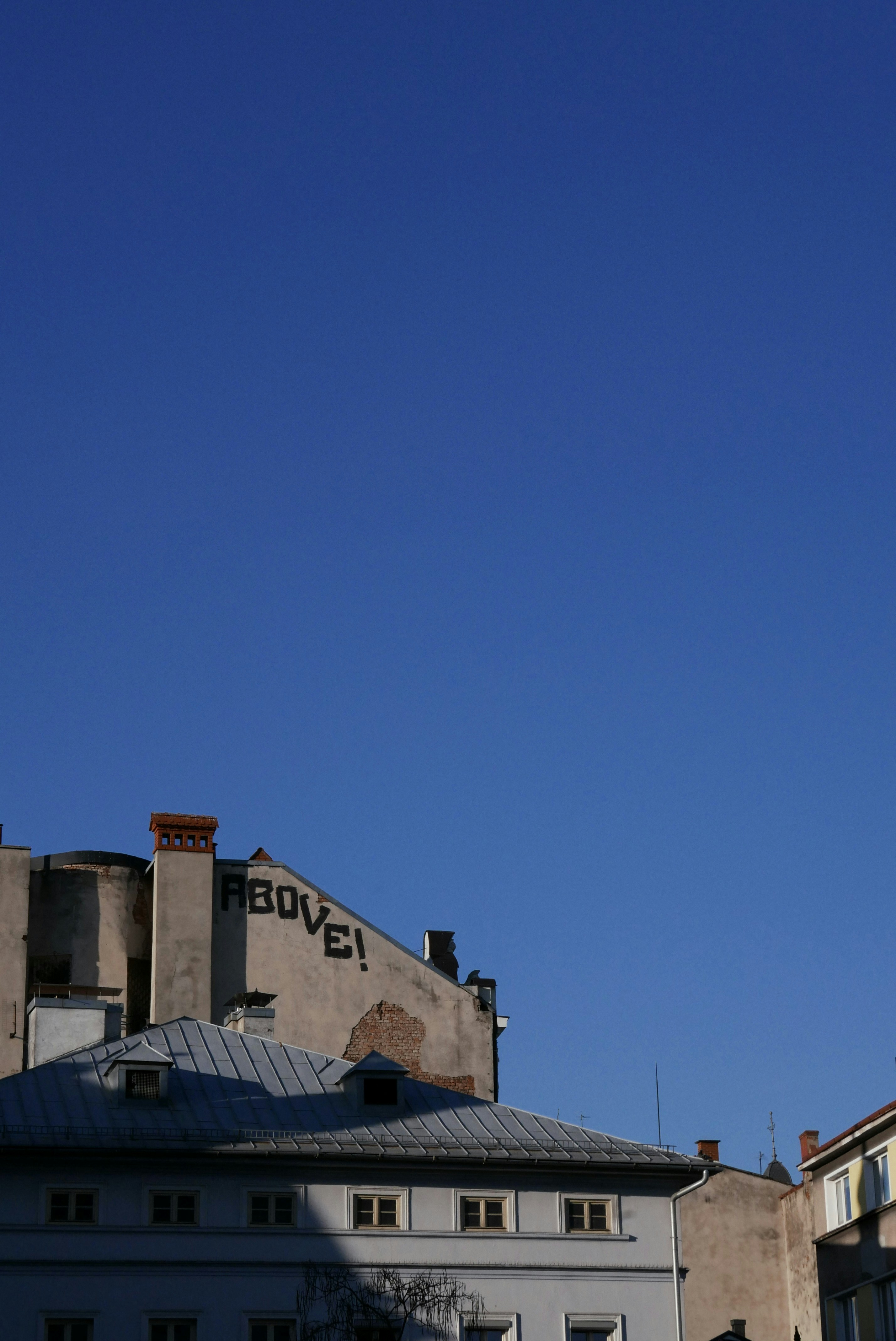 Rising Above the Rooftops: A Clear Blue City Sky Over Quiet Facades