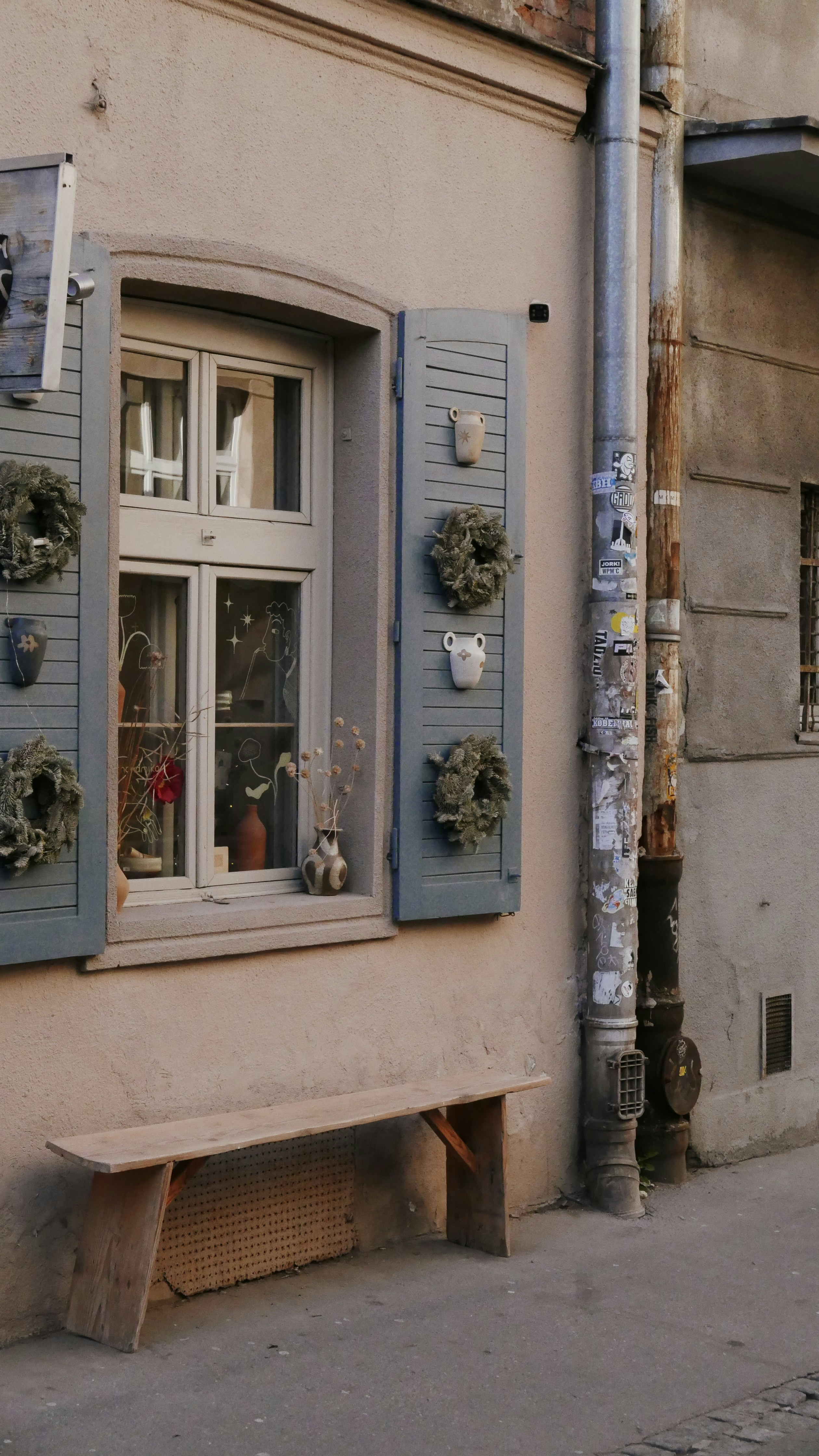 Blue Shuttered Windows with Wreaths on a Quiet European Facade