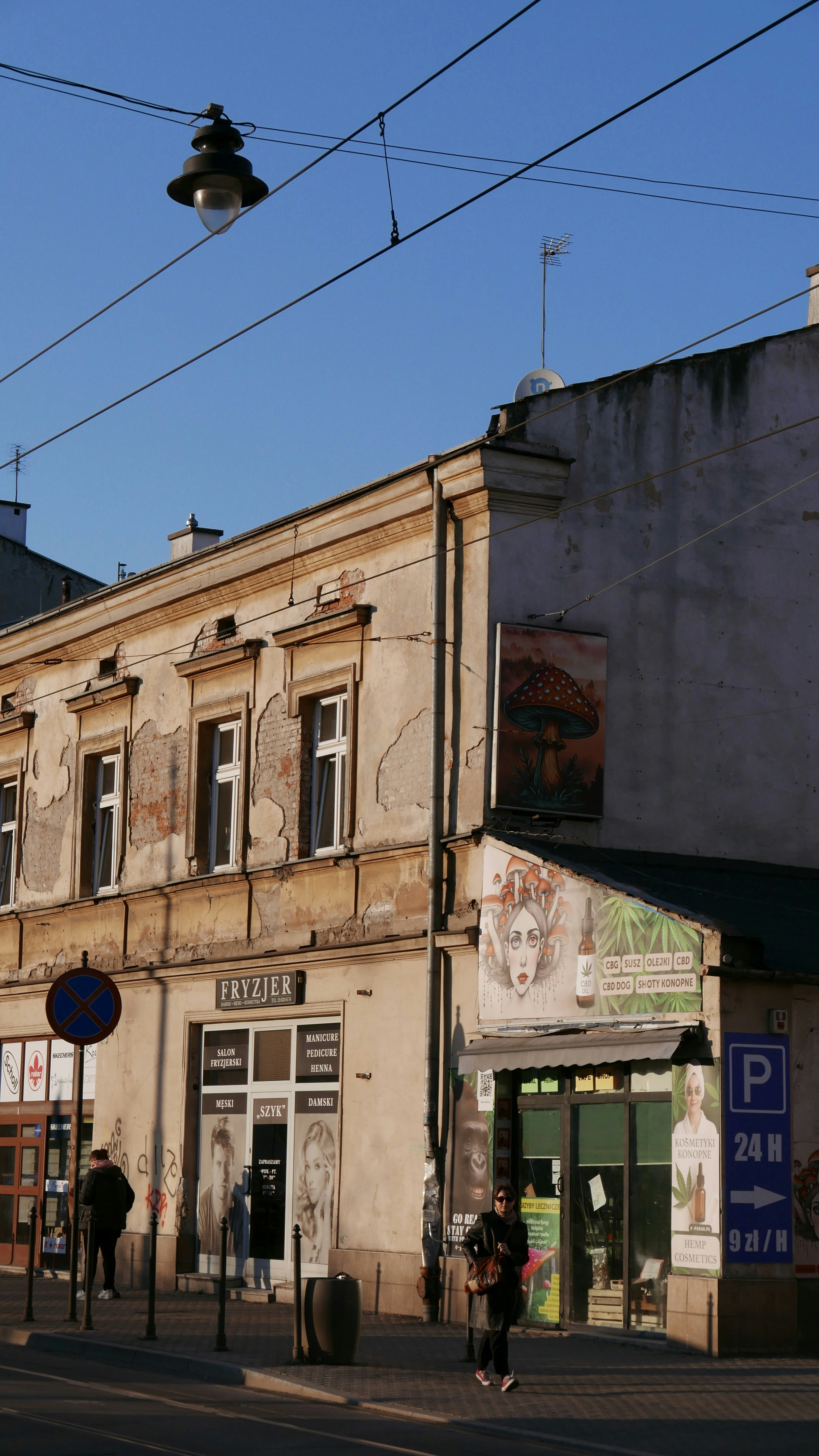 Sunlit Facade of a Weathered Corner Shop with Street-Level Activity