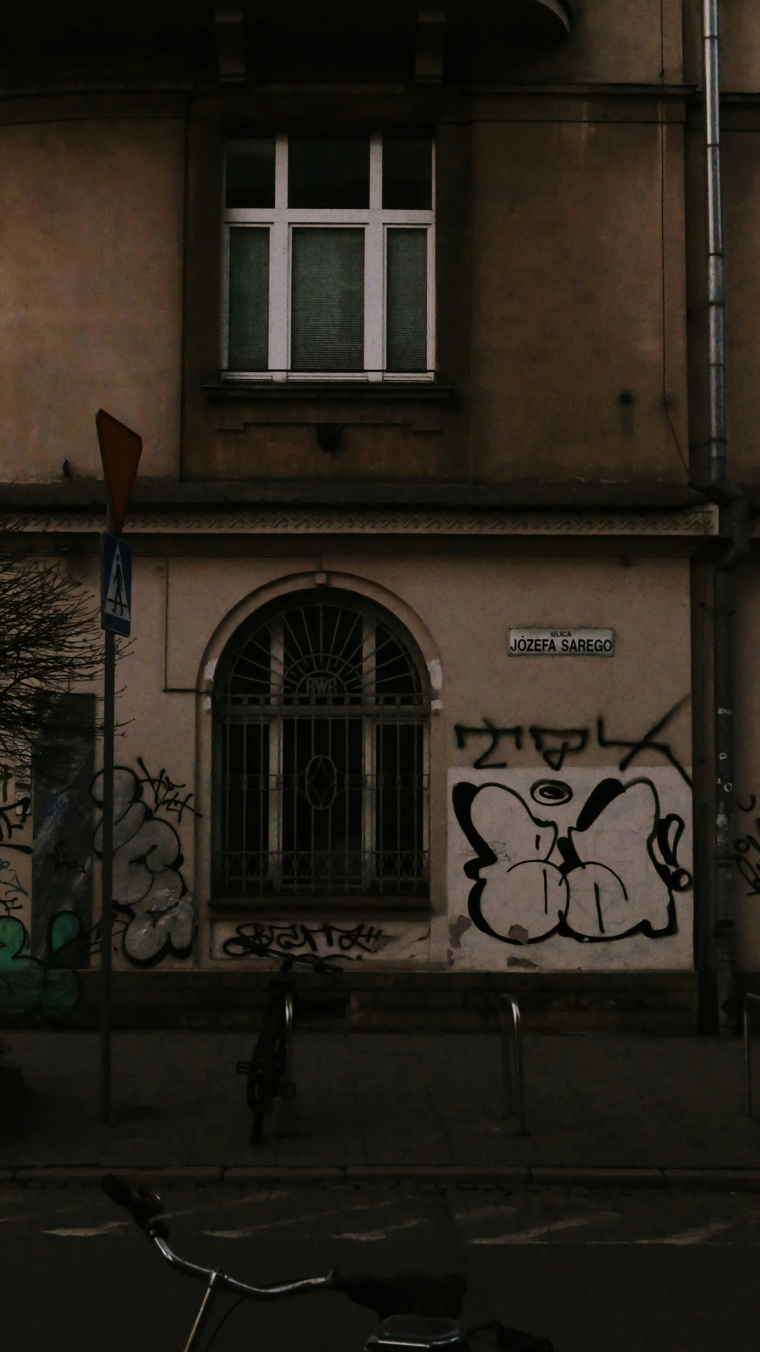 Graffiti and Archway Under a Dim City Window