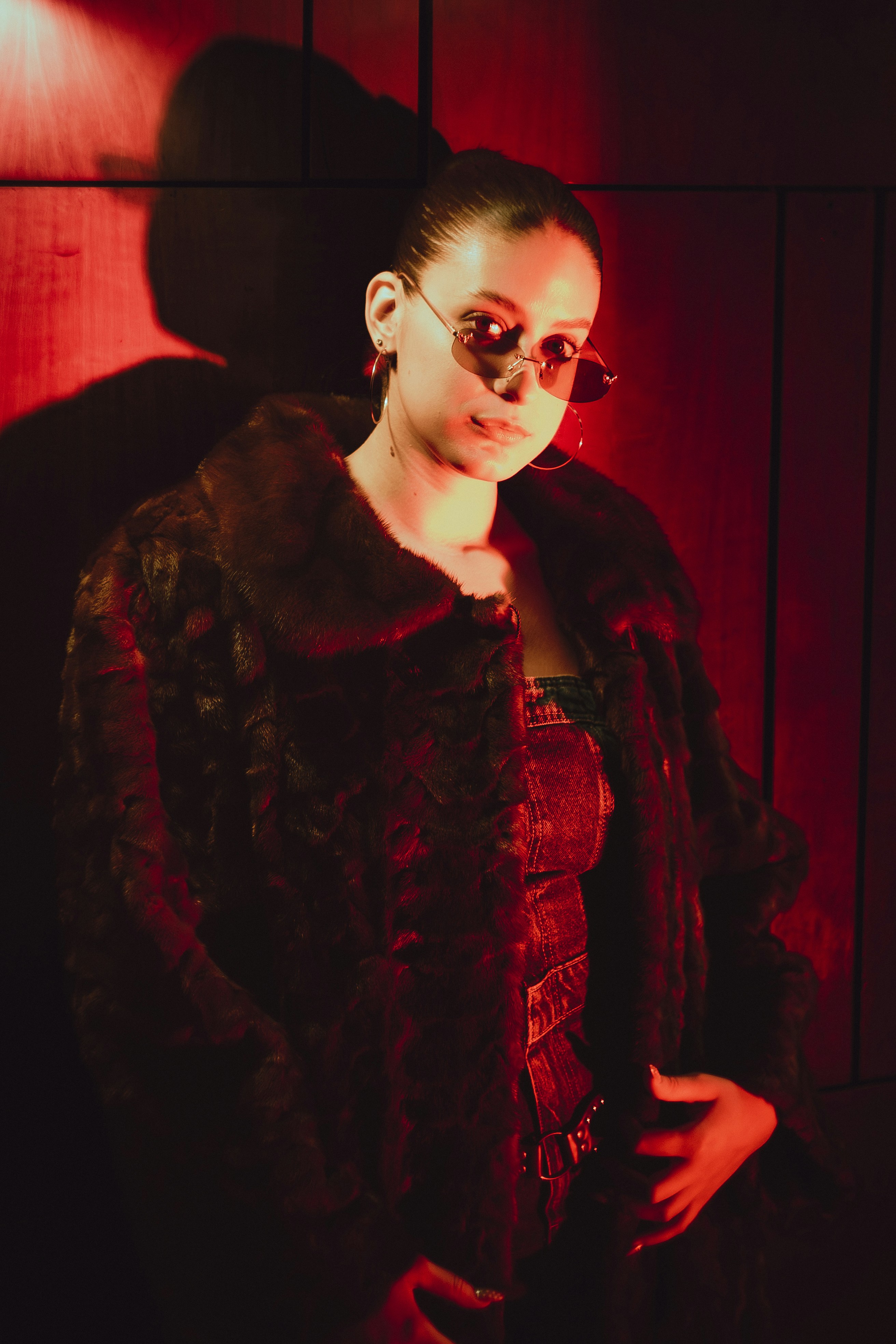 Red-lit Enigma: A Quiet Confidence in the Neon Glow