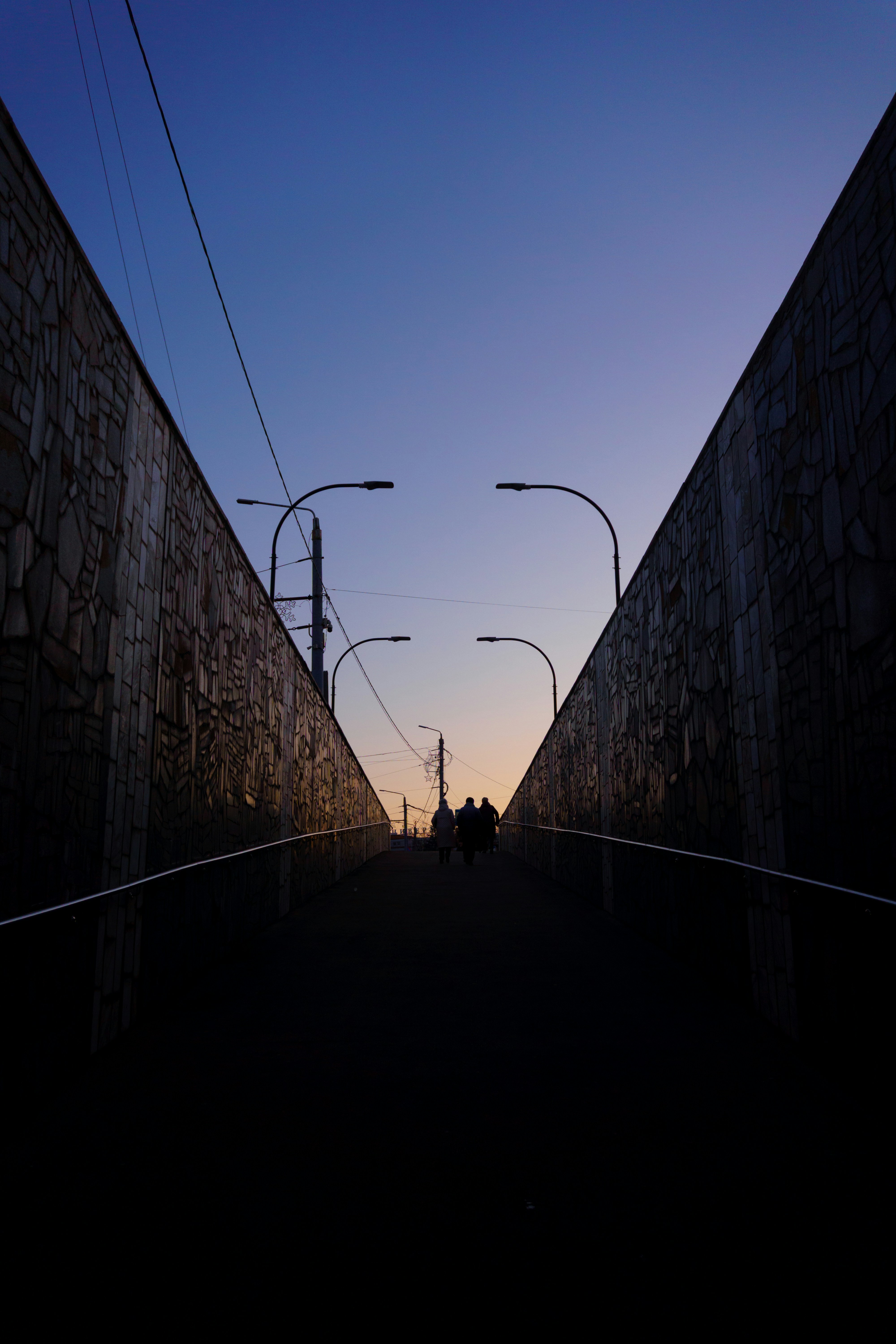 Silhouette Crossing: A Sunset Descent Between Rustic Walls