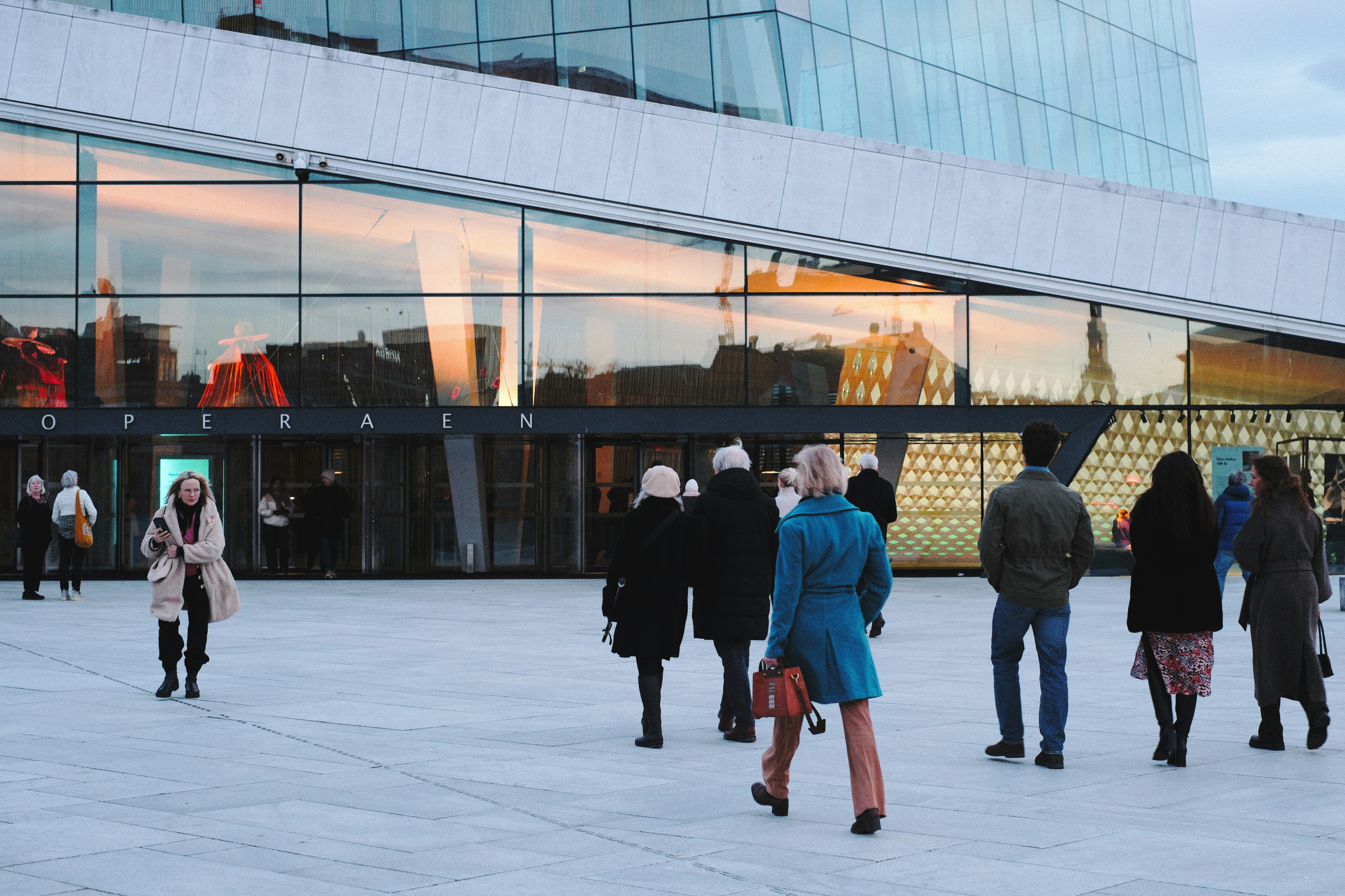 Urban Threshold: People Gather at a Modern Glass Entrance