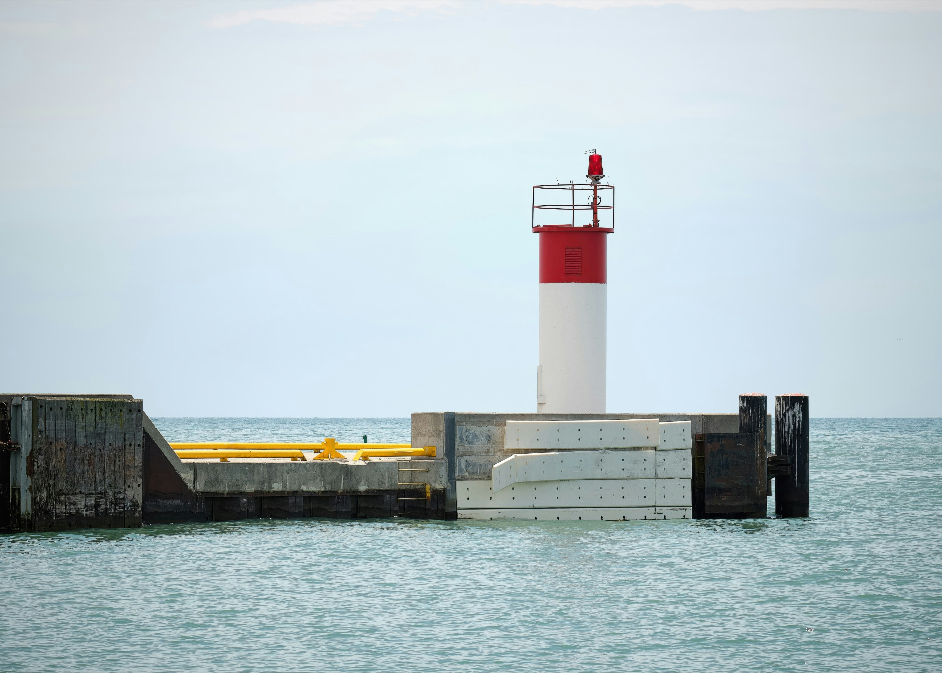 Red and White Beacon at the End of Calm Seas