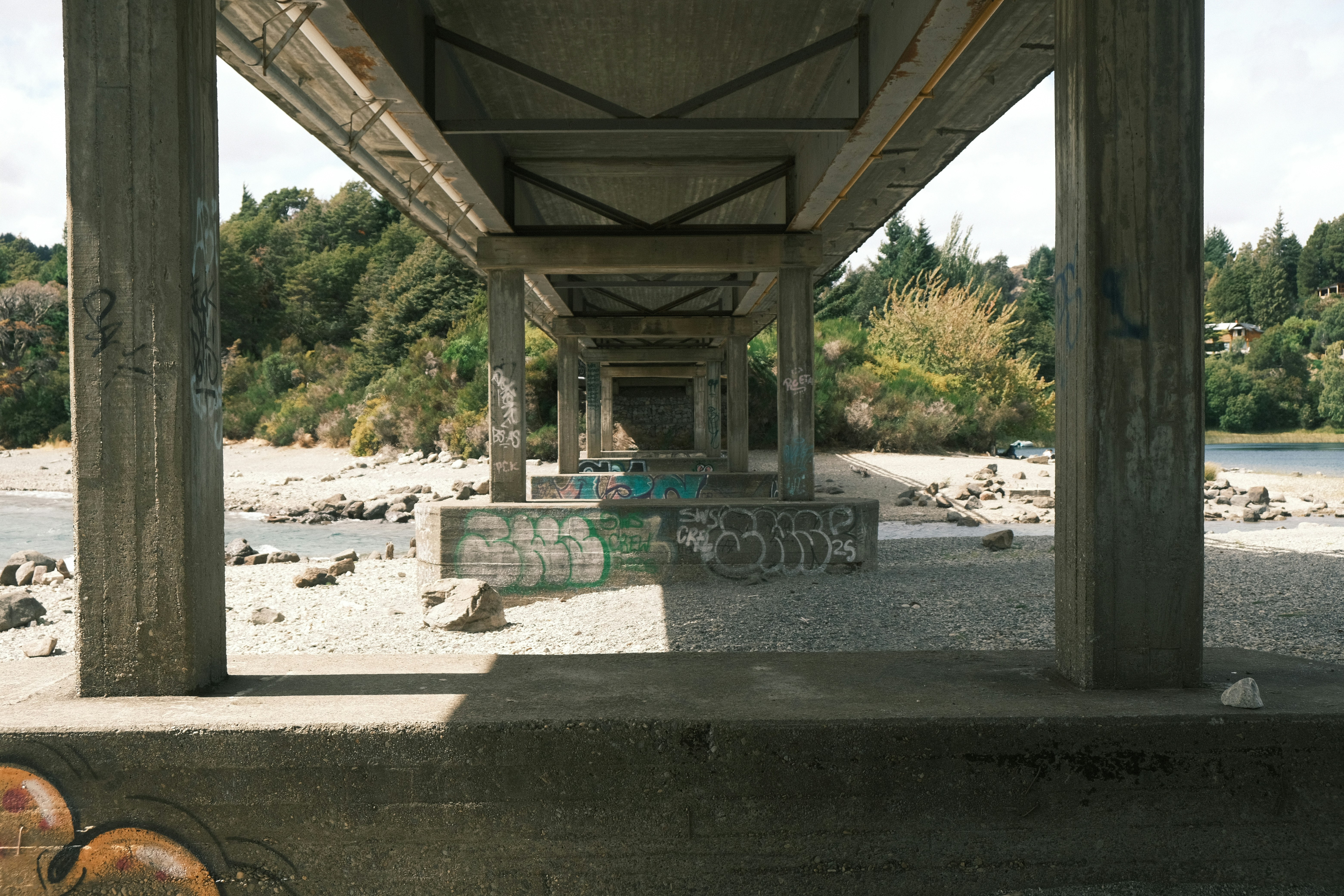 Under the Pier: Concrete Columns Recede into Green Light