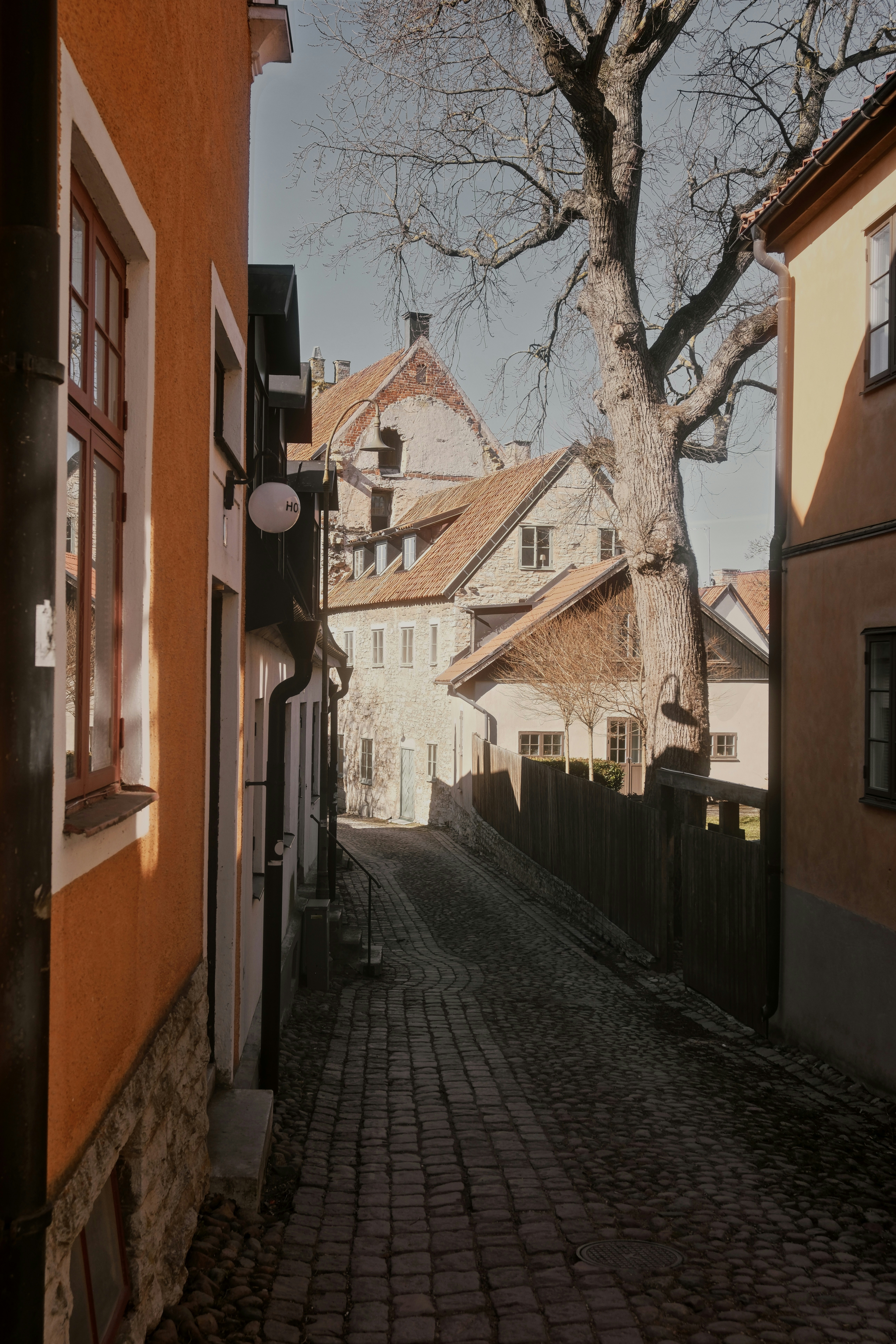 Sunlit Callejon: A Cobblestone Path Between Warm Facades