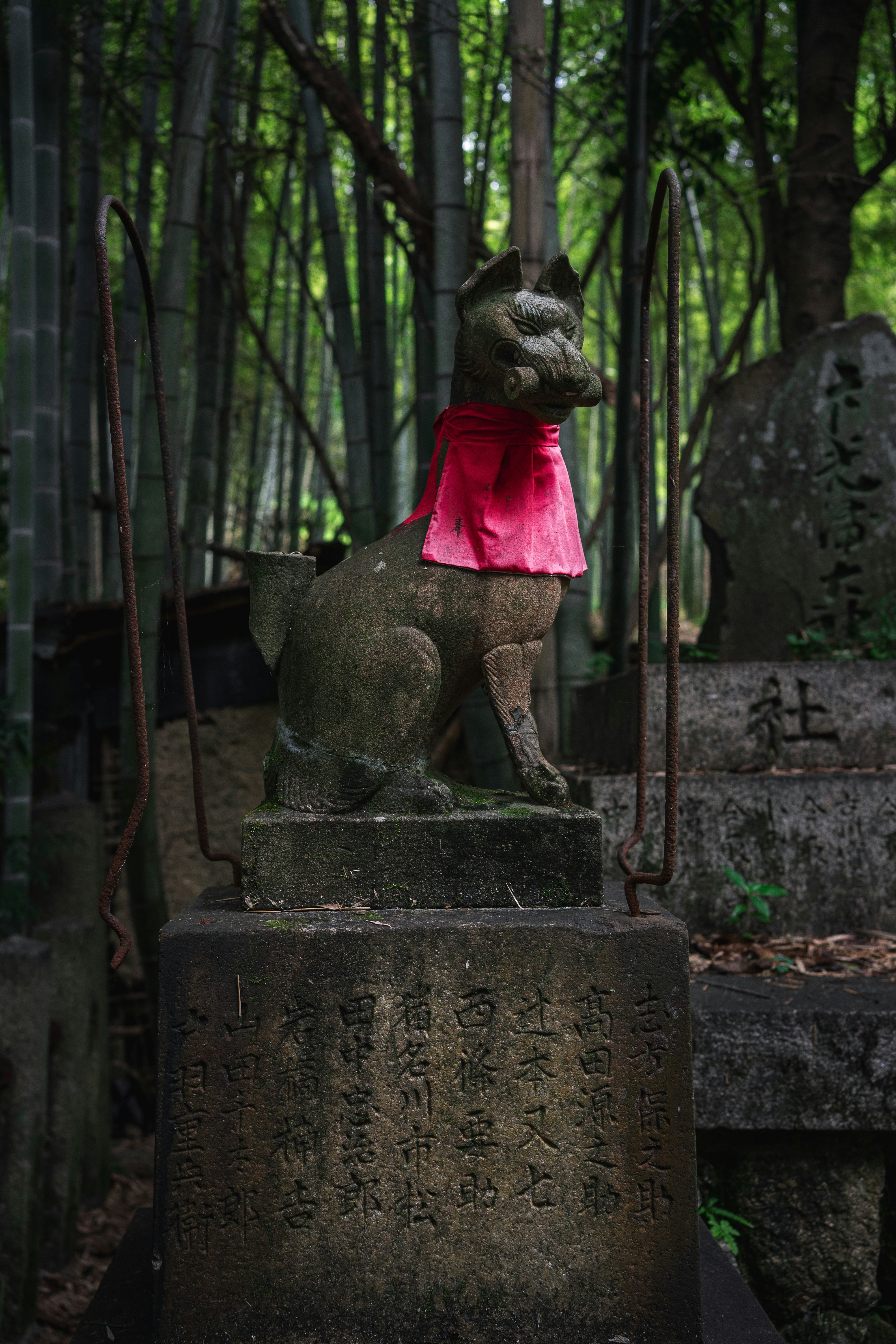 Scarlet scarf on a stone fox in a quiet forest