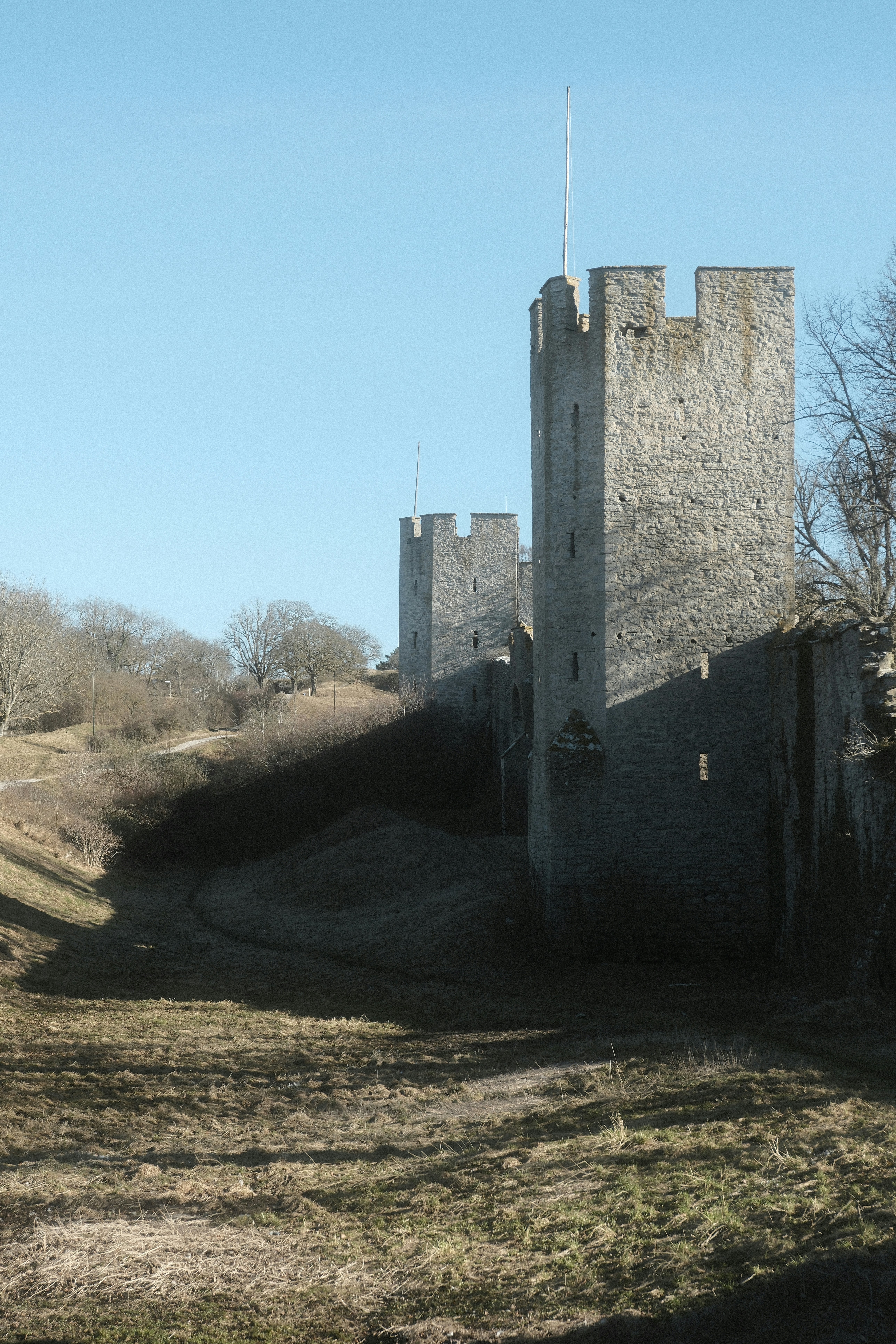 Medieval silhouette: sunlit fortress towers by a dried riverbank