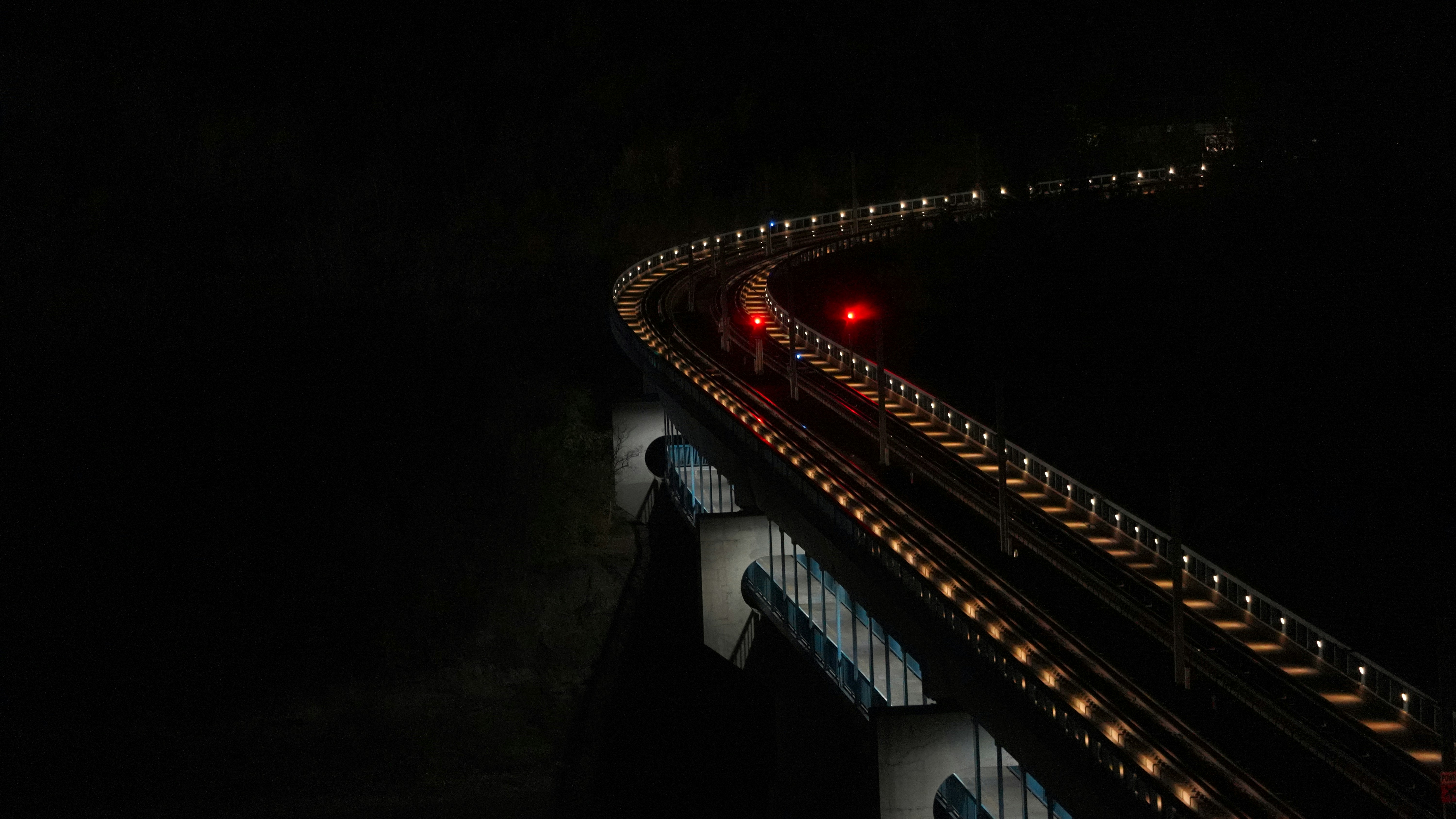 Curving Night Route: A Ripple of Lights on a Distant Bridge