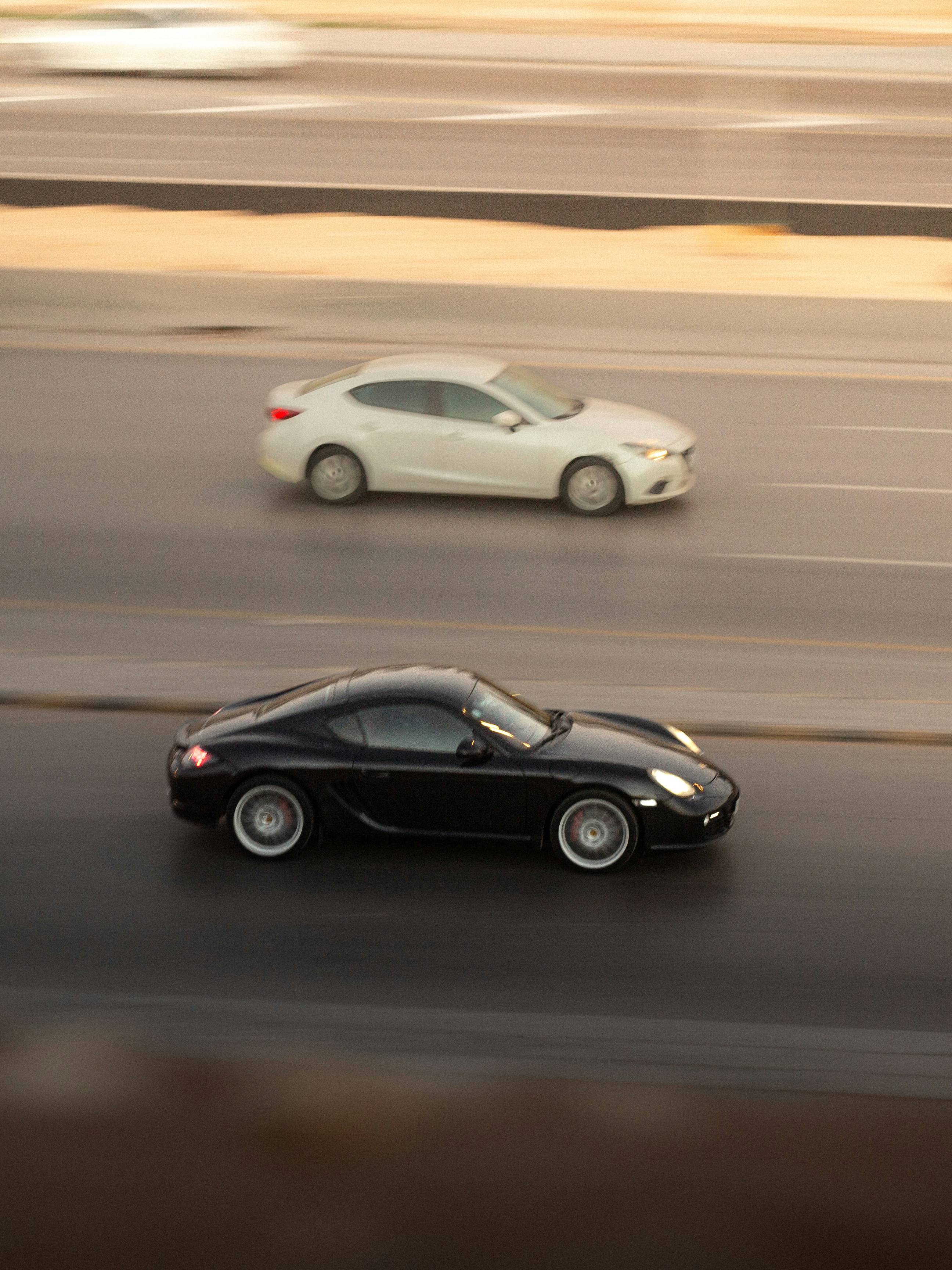 Two Cars in Motion: A Blur of Speed Across a Desert Road