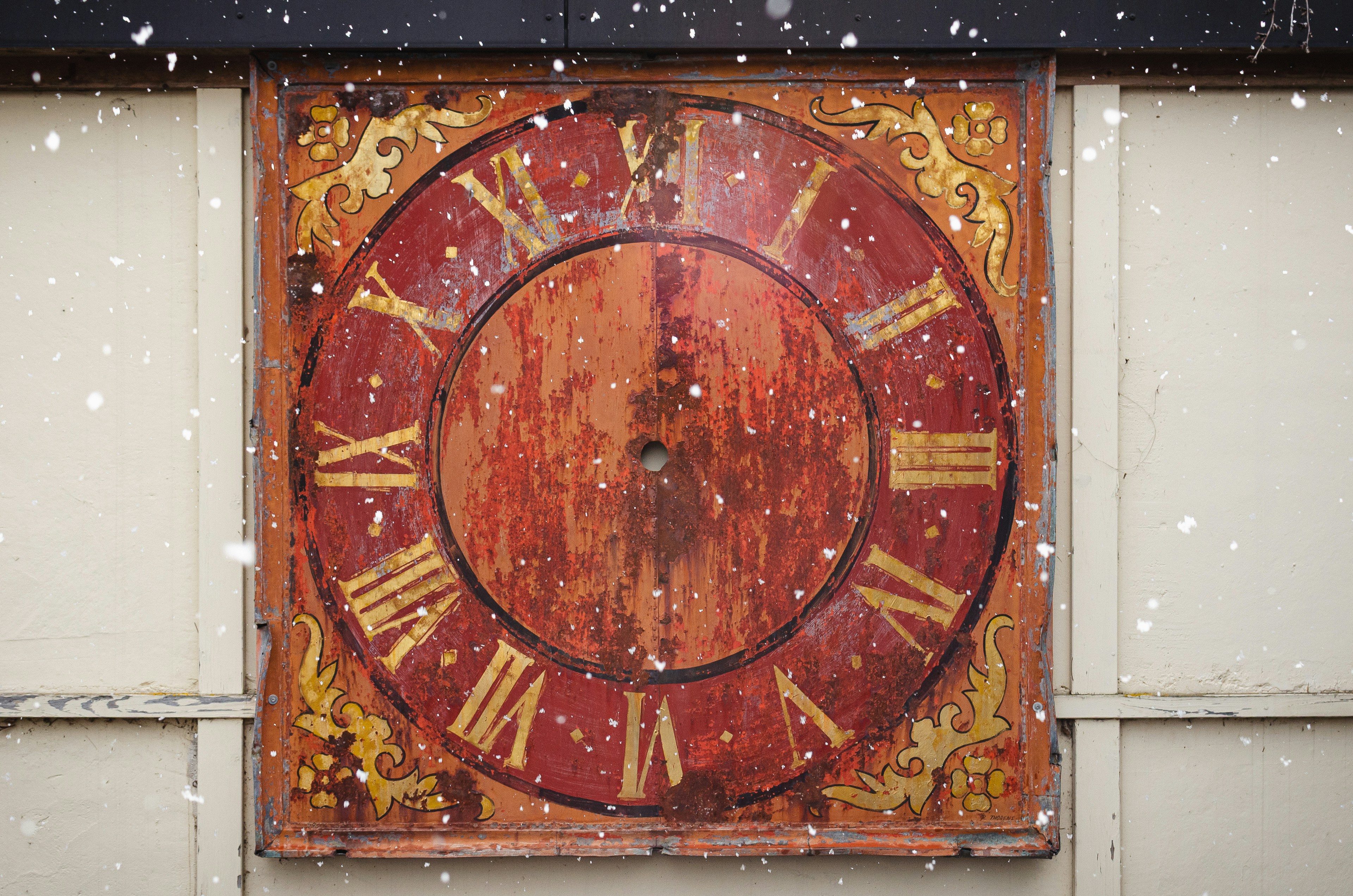 Weathered Clock Face: Red-Rimmed Roman Numerals in Snow