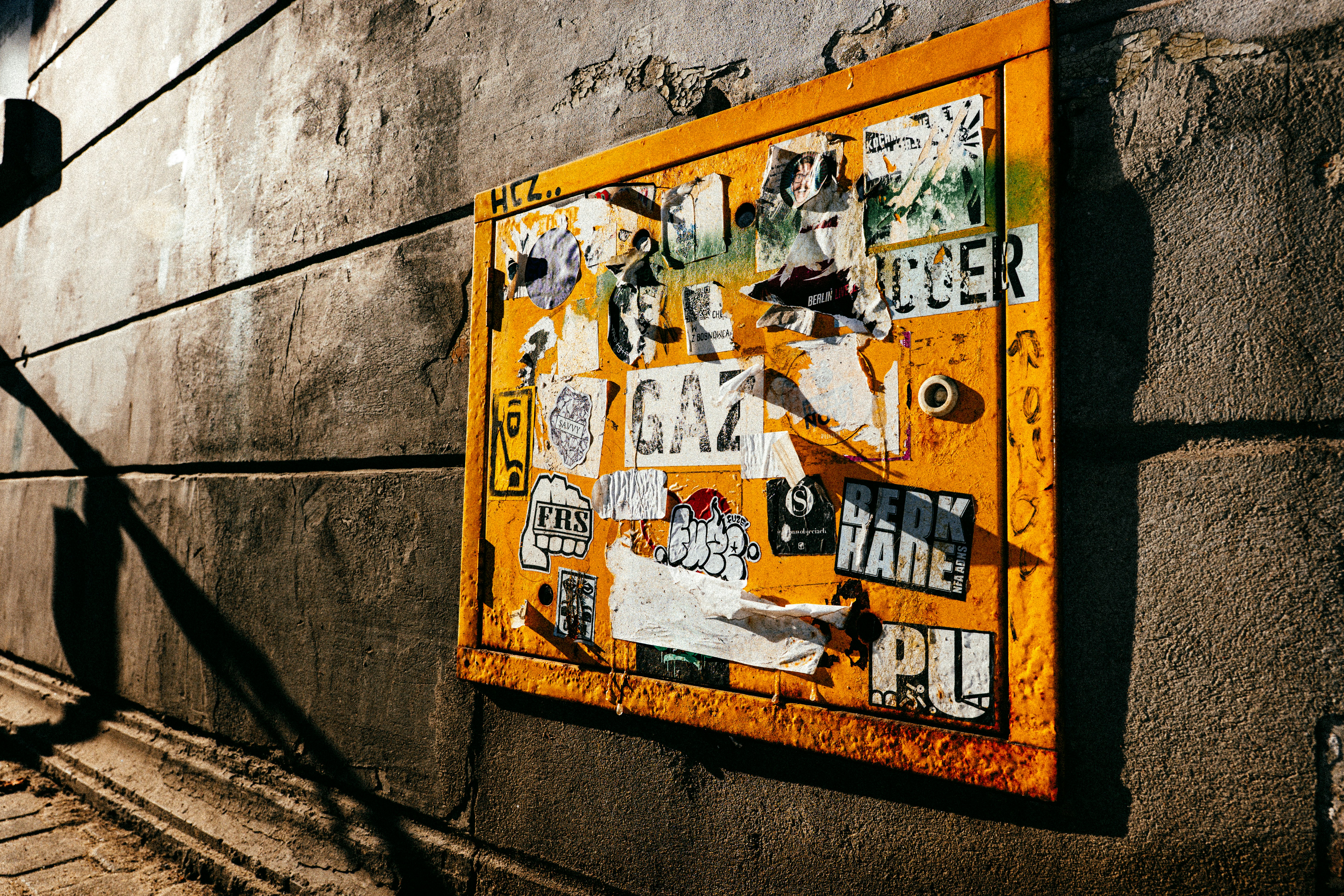 Rusty Orange Graffiti Panel on a Sunlit Concrete Wall